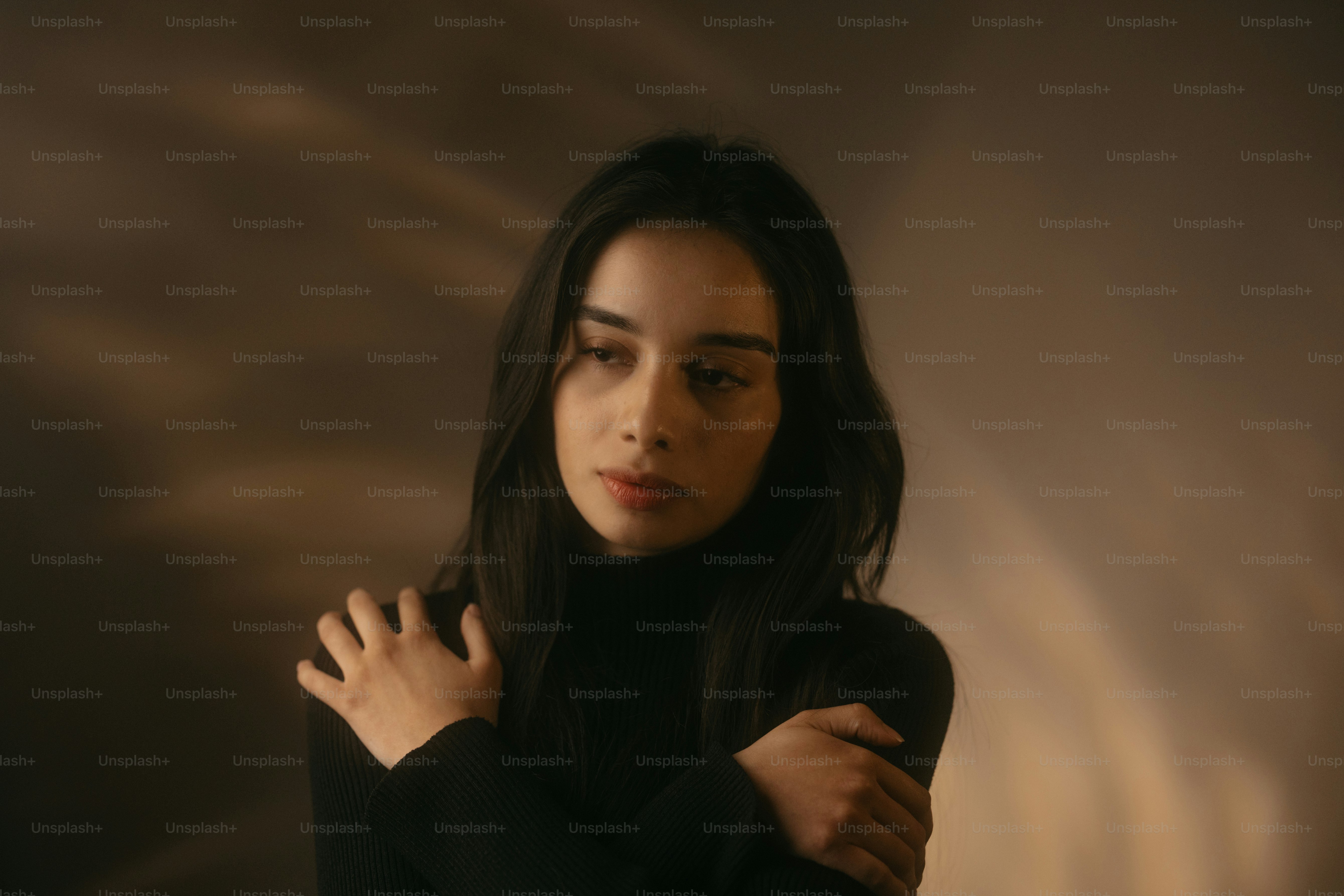 A woman embraces herself looking somber. photo – Portrait Image on Unsplash