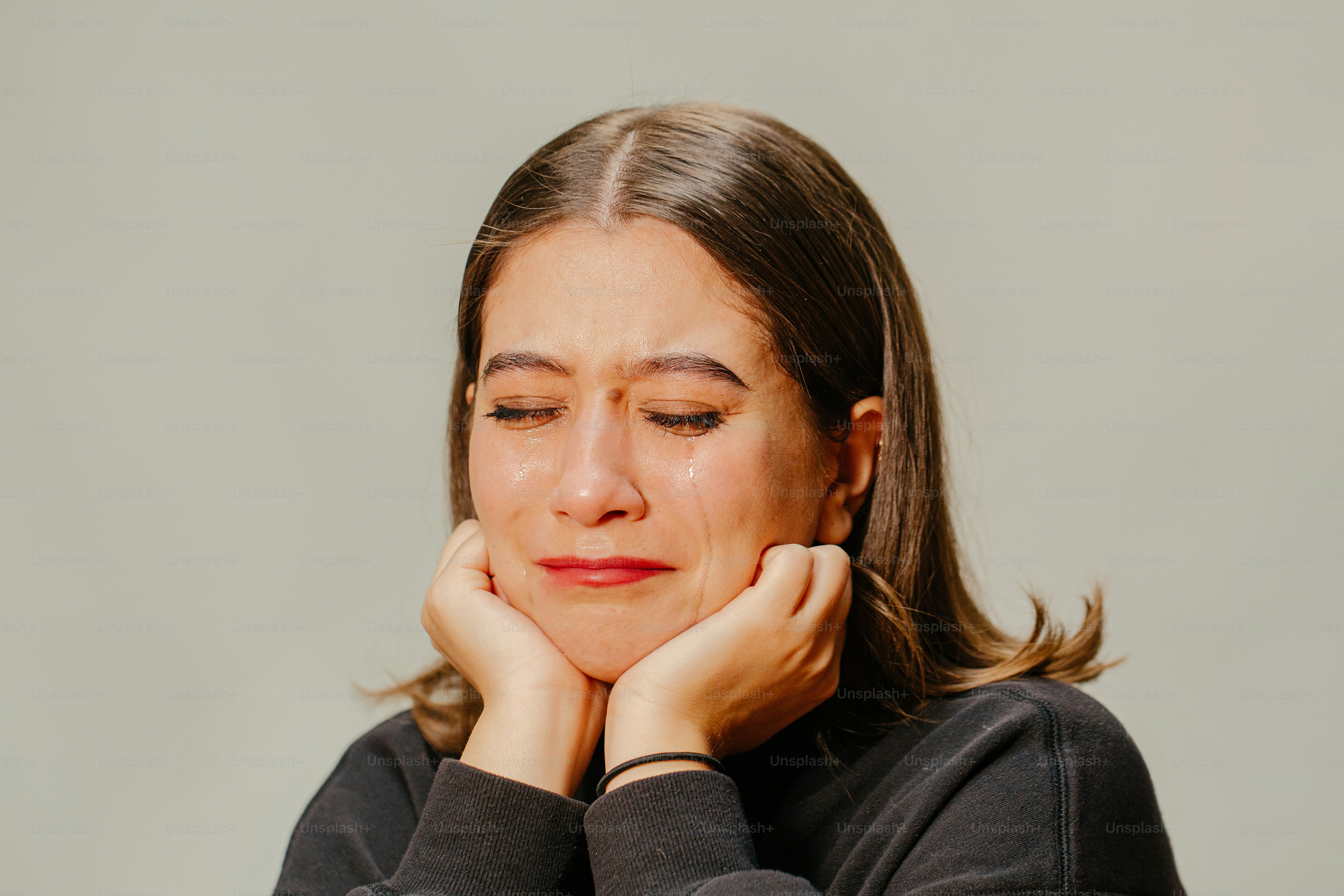 Woman is crying with closed eyes and hands on chin. photo – Crying ...