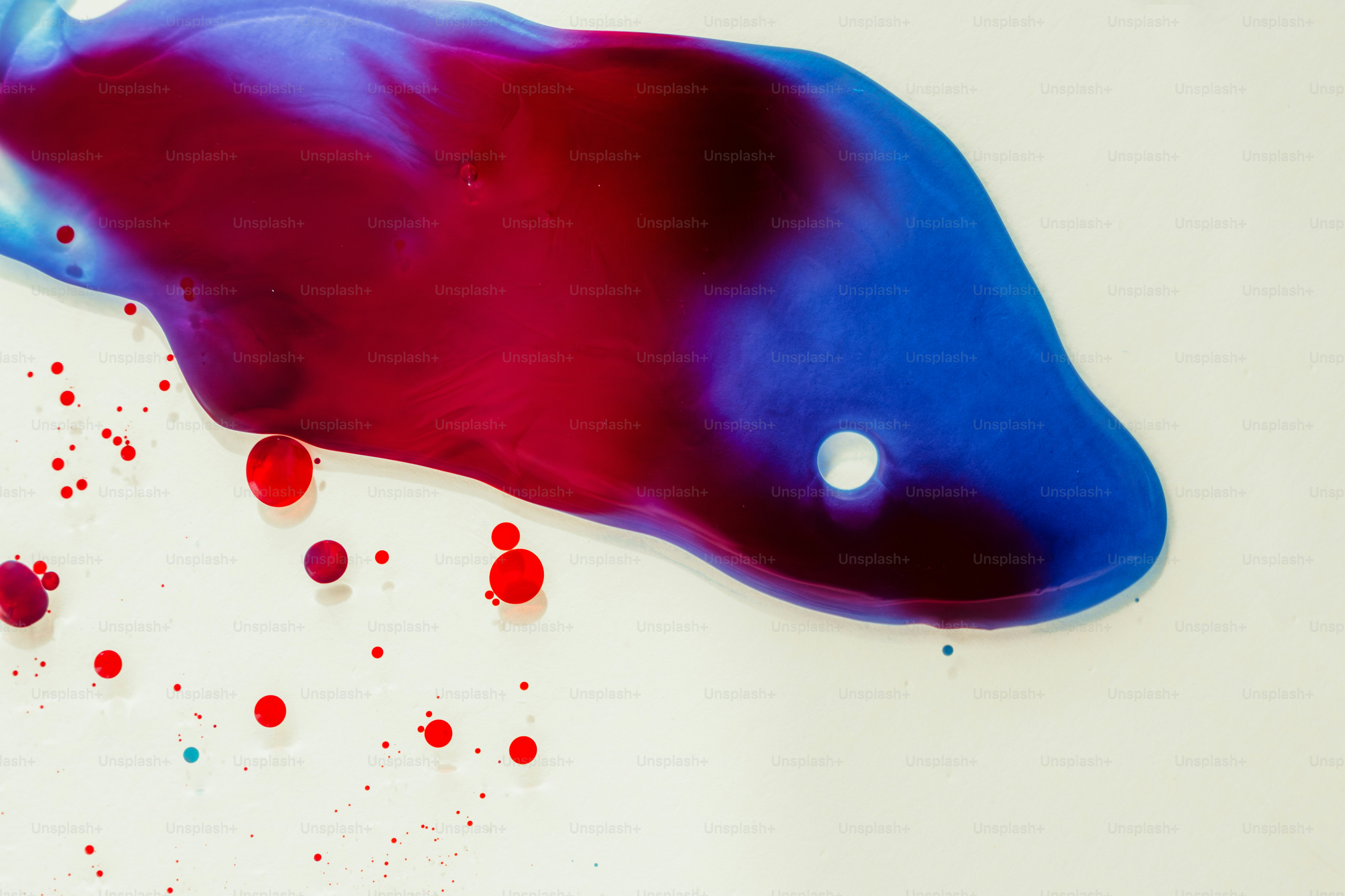 Tinta vermelha e azul são espalhadas em uma superfície. foto – Imagem ...