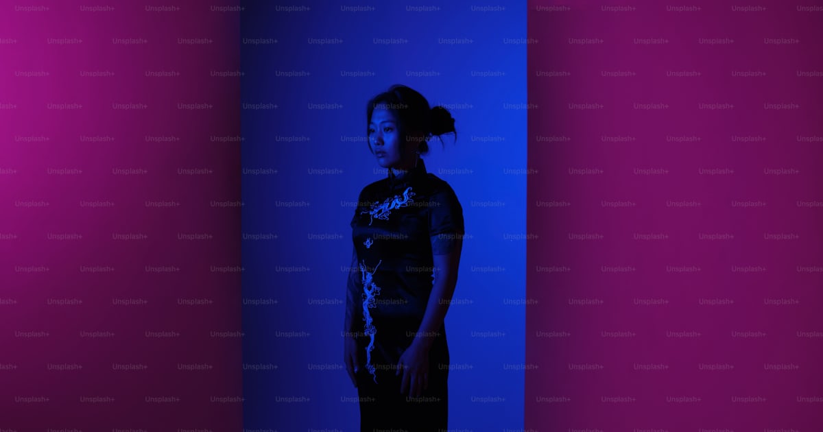 青と紫の光でポーズをとっているガウンを着た女性。の写真 Unsplashの肖像の画像