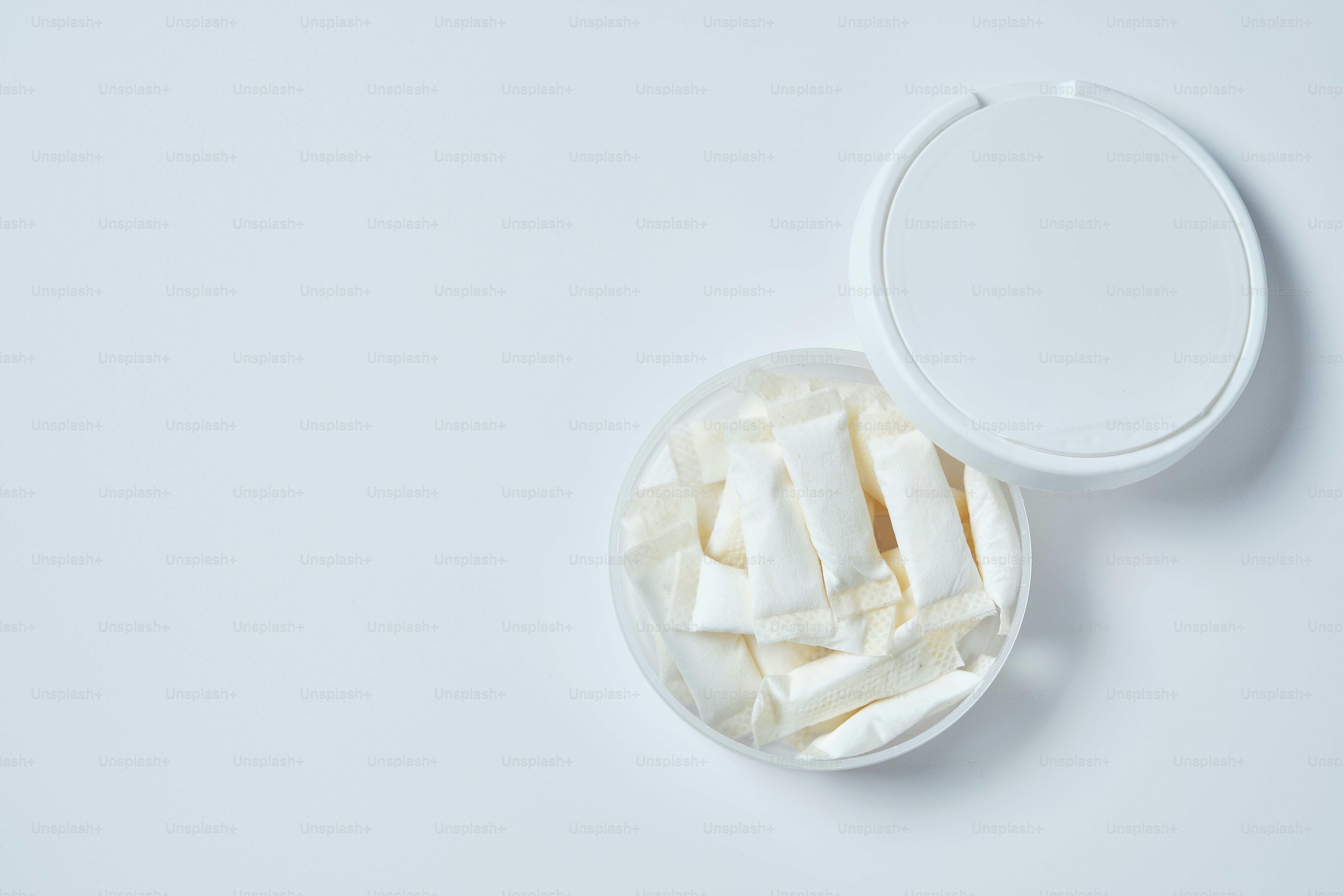 A container of nicotine pouches sits open. photo – Snus Image on Unsplash
