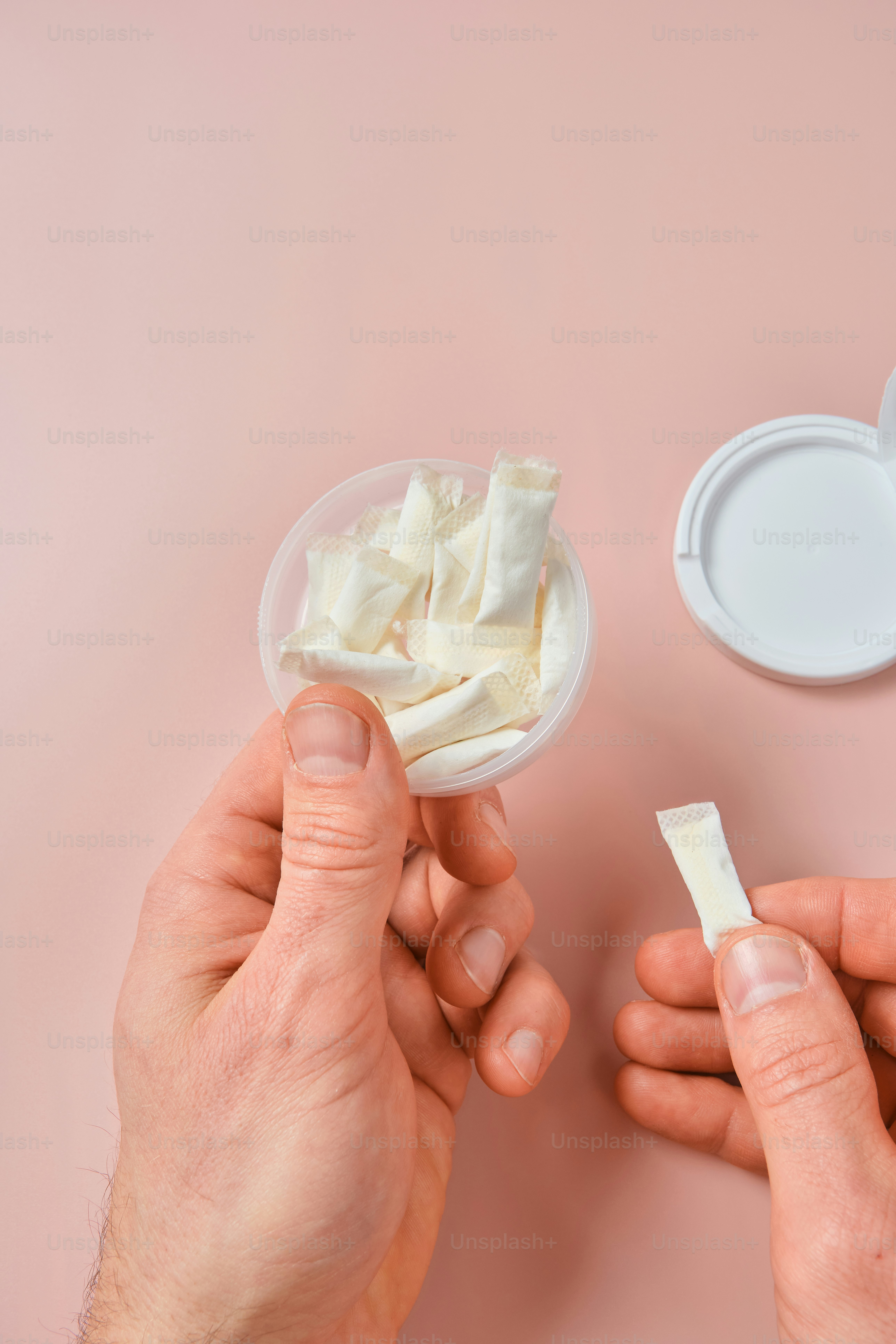 Person holding a container of snus packets. photo – Snus Image on Unsplash