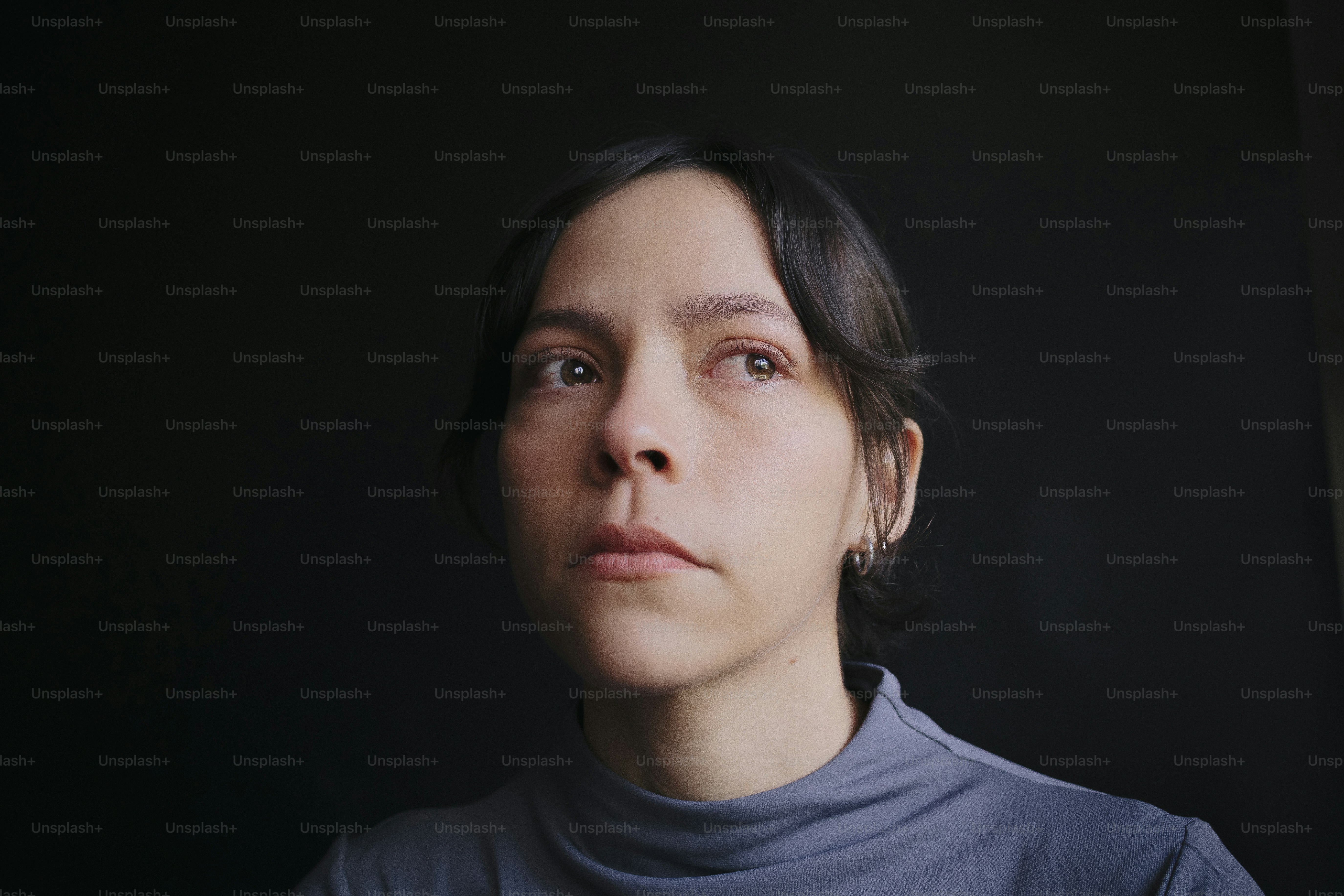 Woman looks off to the side with contemplative expression. photo ...