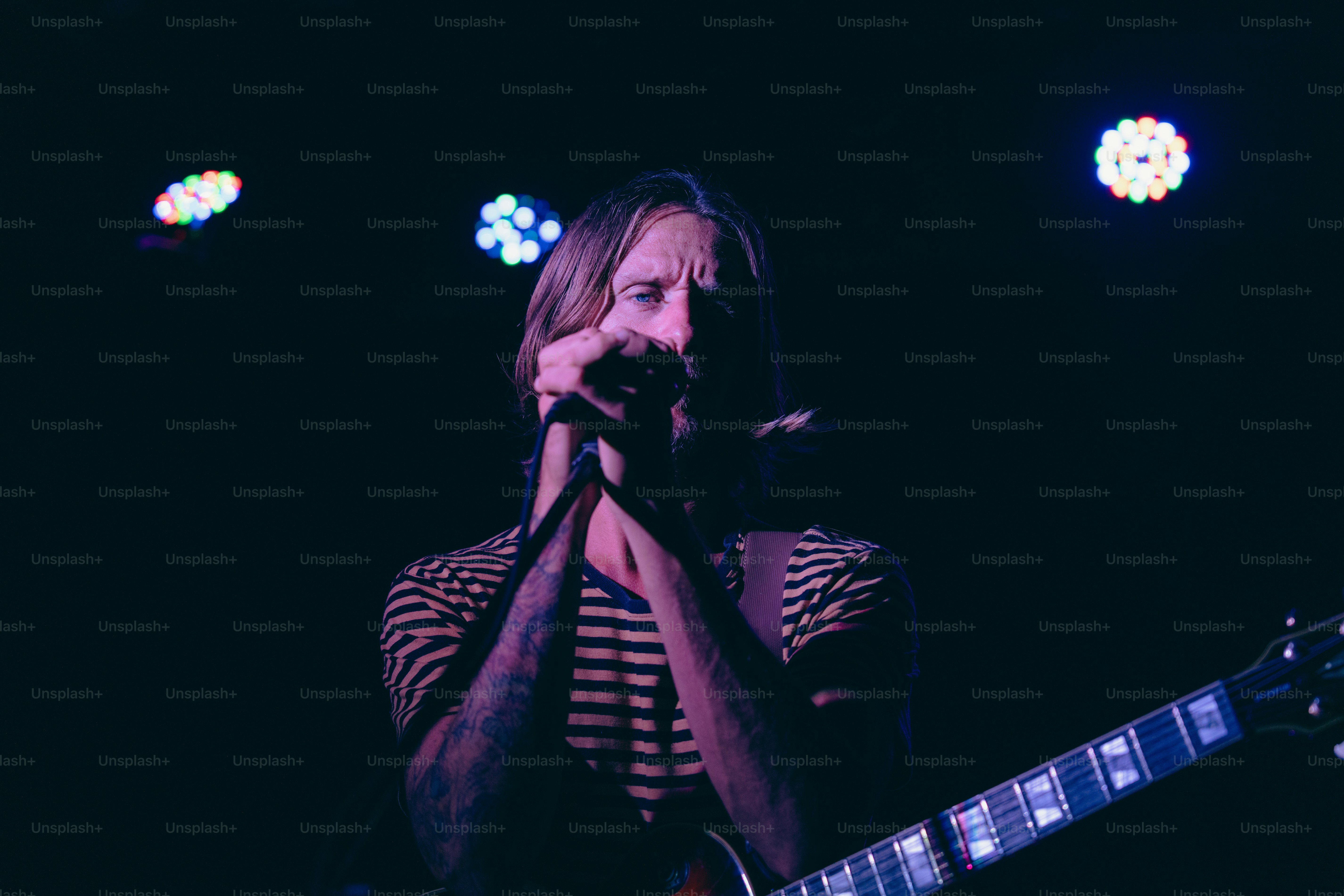 A musician plays harmonica on stage. photo – Man Image on Unsplash