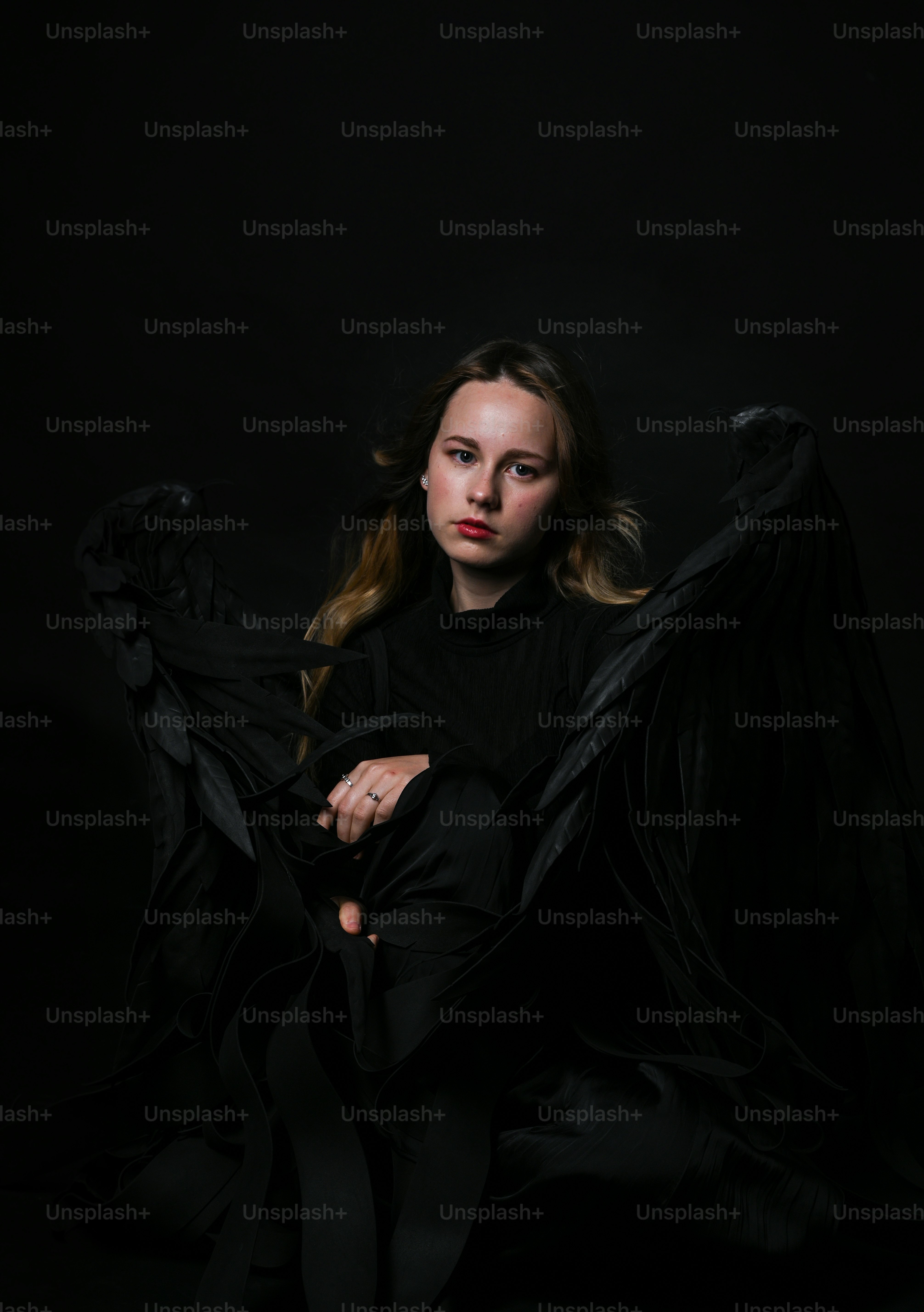 Woman poses in black attire against dark background. photo – Portrait ...