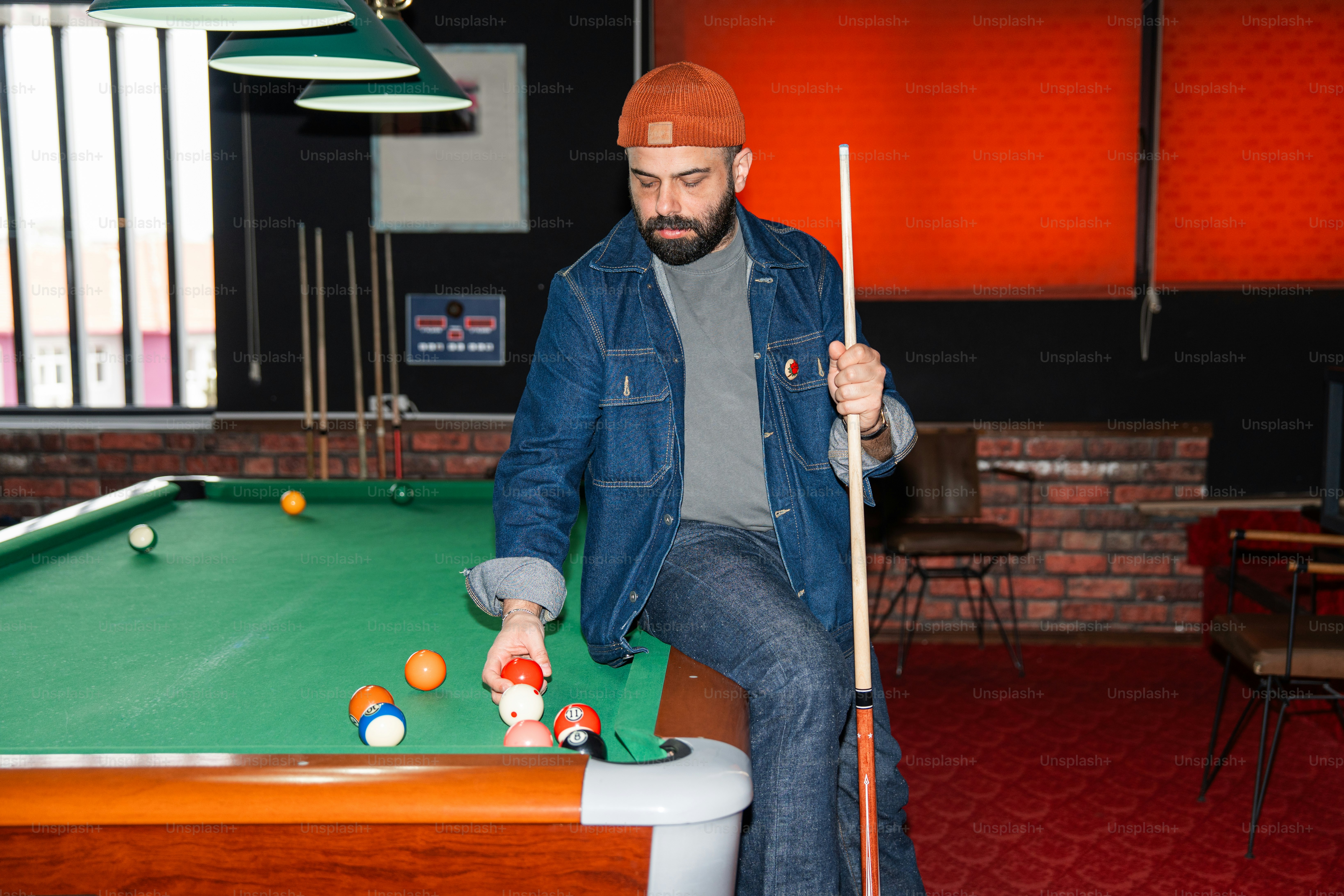 Pool balls are scattered across the green felt table. photo – Friends ...