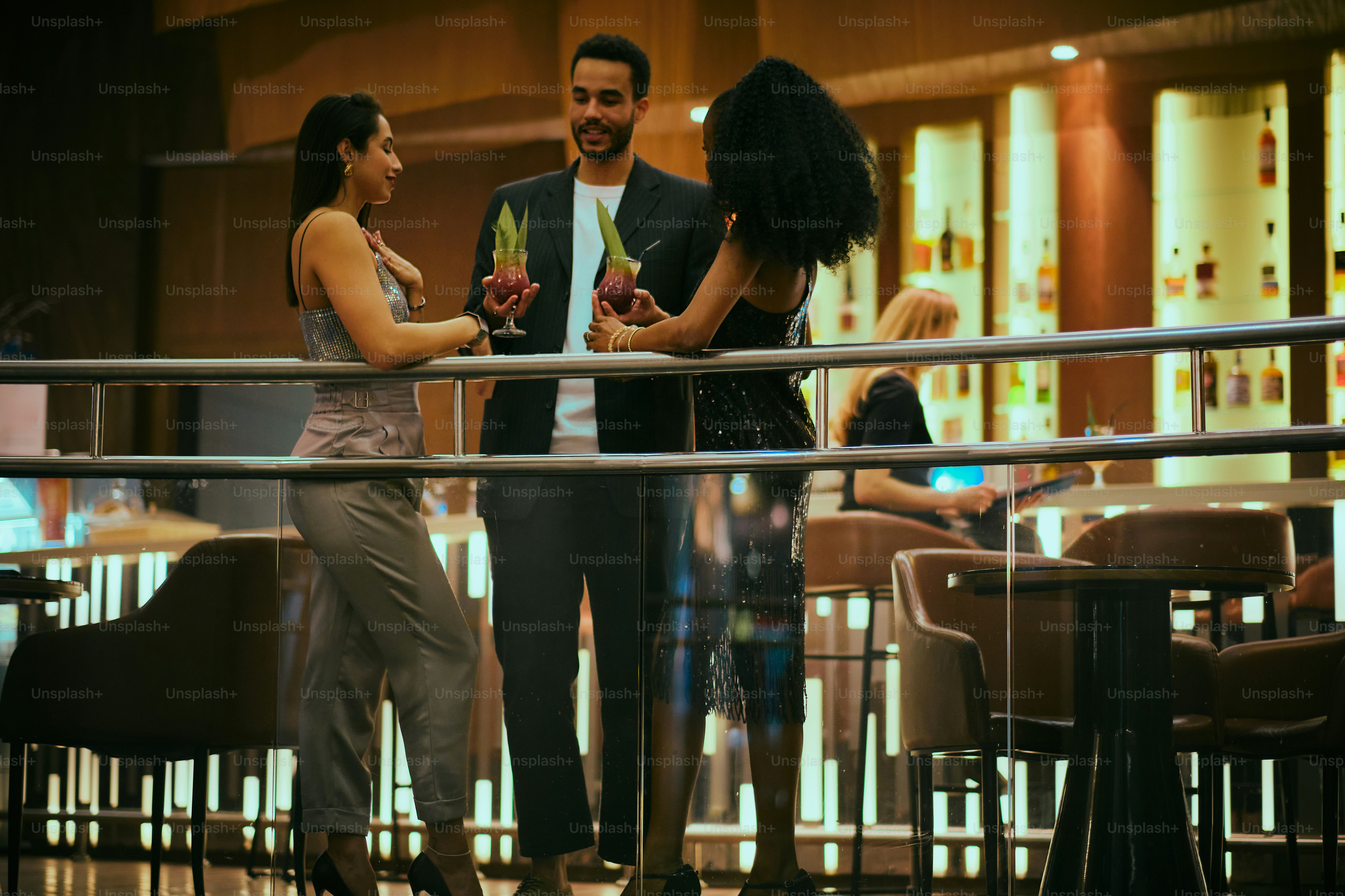 People enjoy drinks and conversation at a bar. photo – People Image on ...