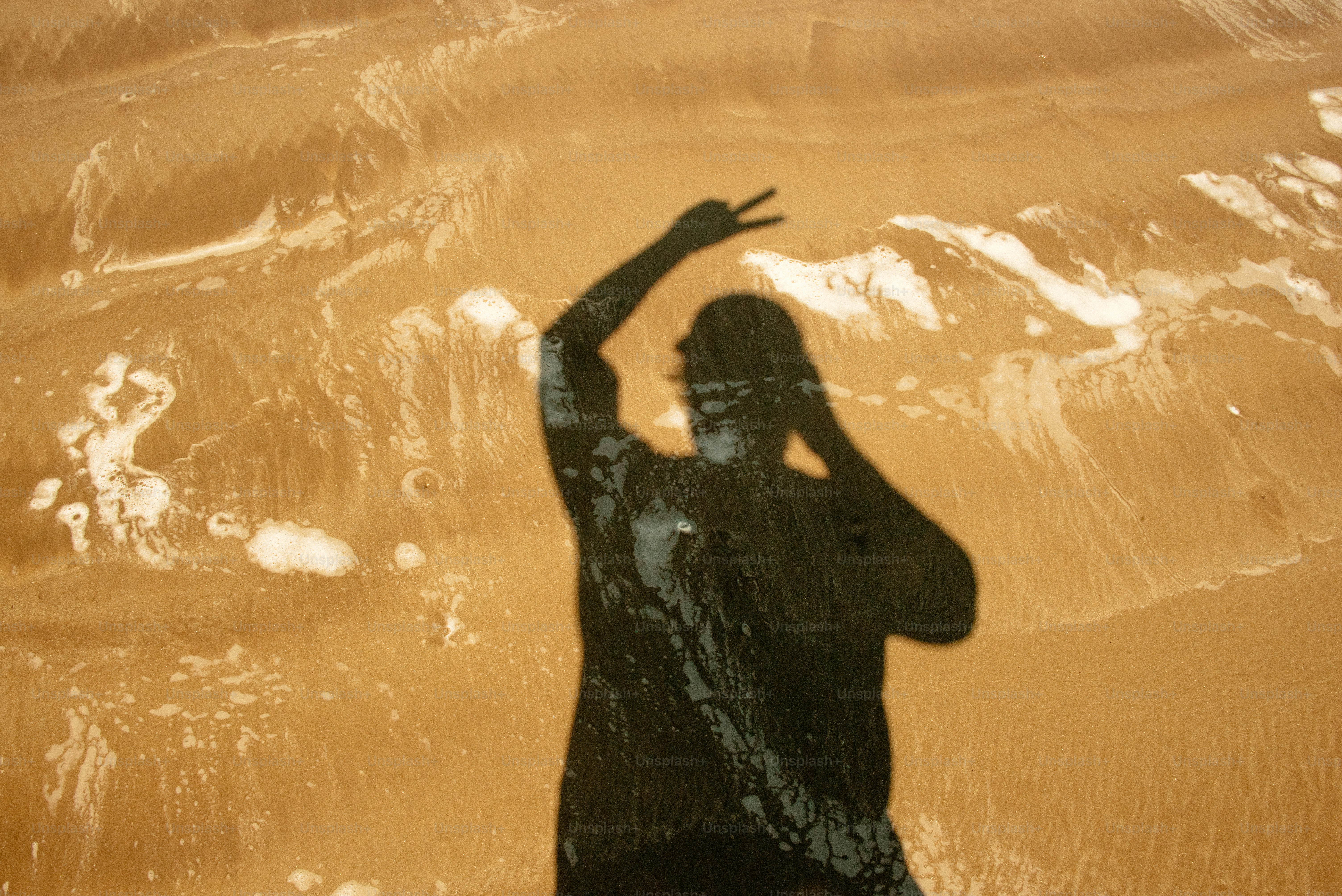 Shadow of a person giving a peace sign. photo – Beach Image on Unsplash