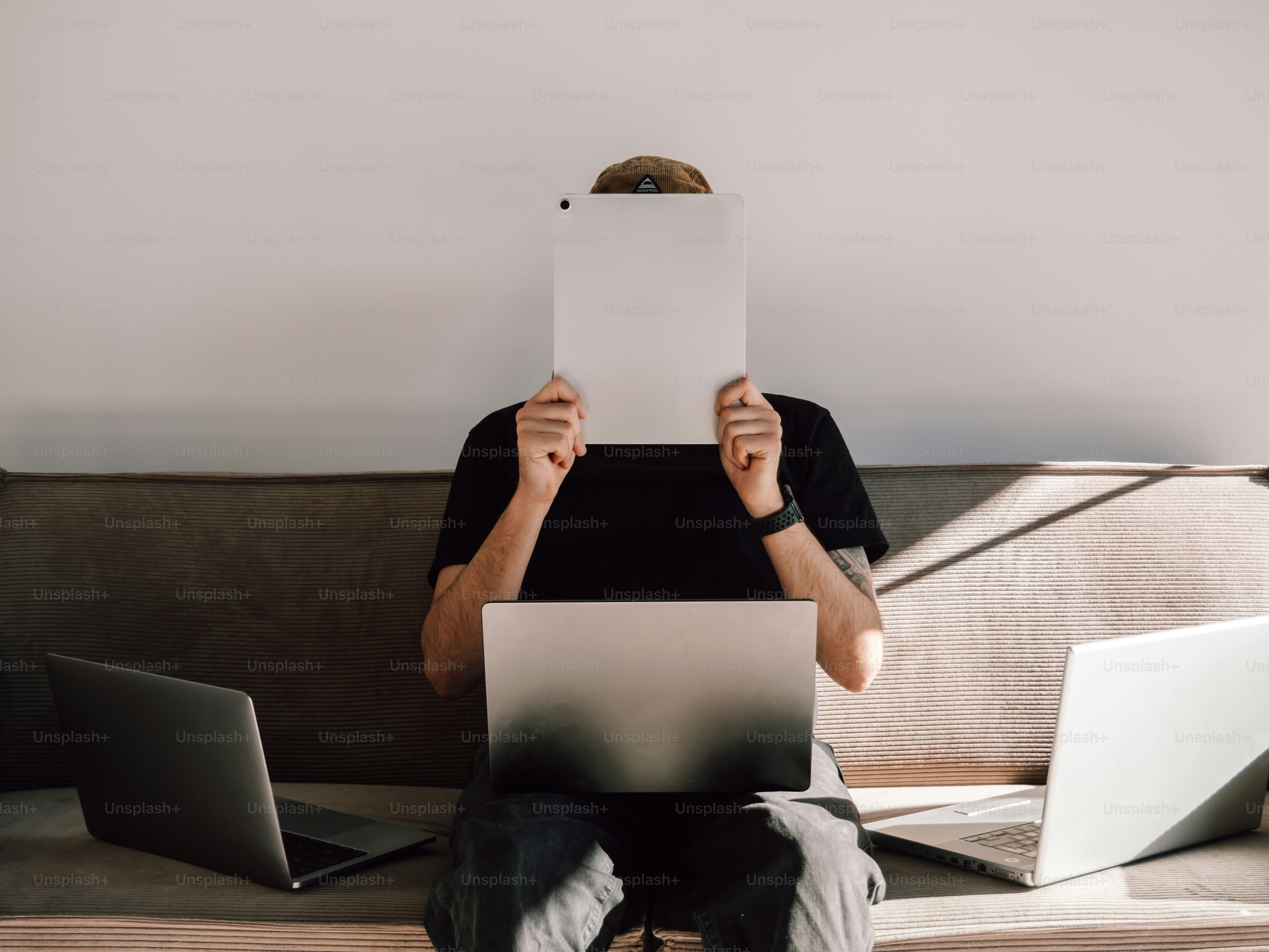 Person hides behind paper while using laptops. photo – Technology Image ...