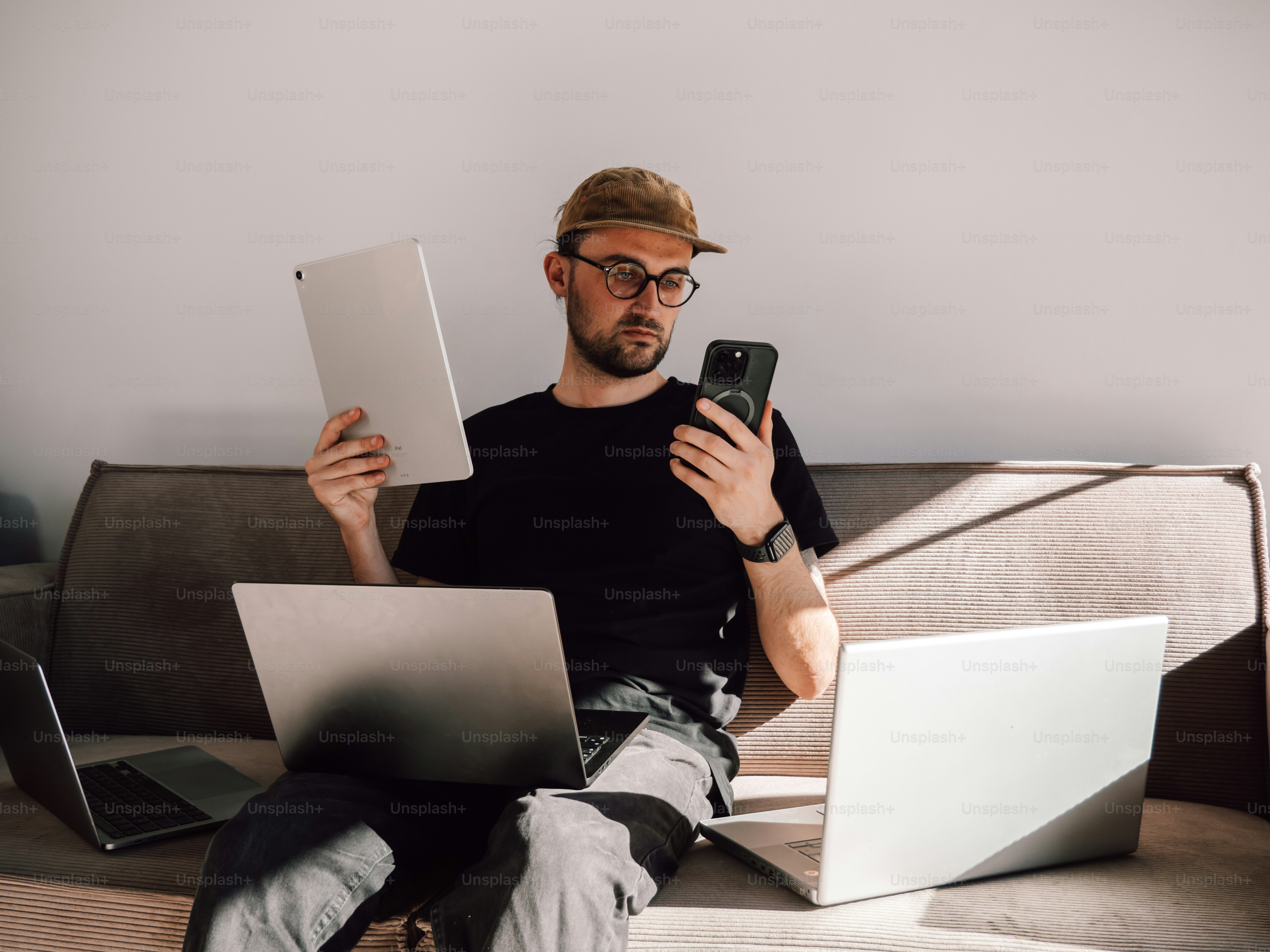 A man is multi-tasking with multiple devices. photo – Technology Image ...