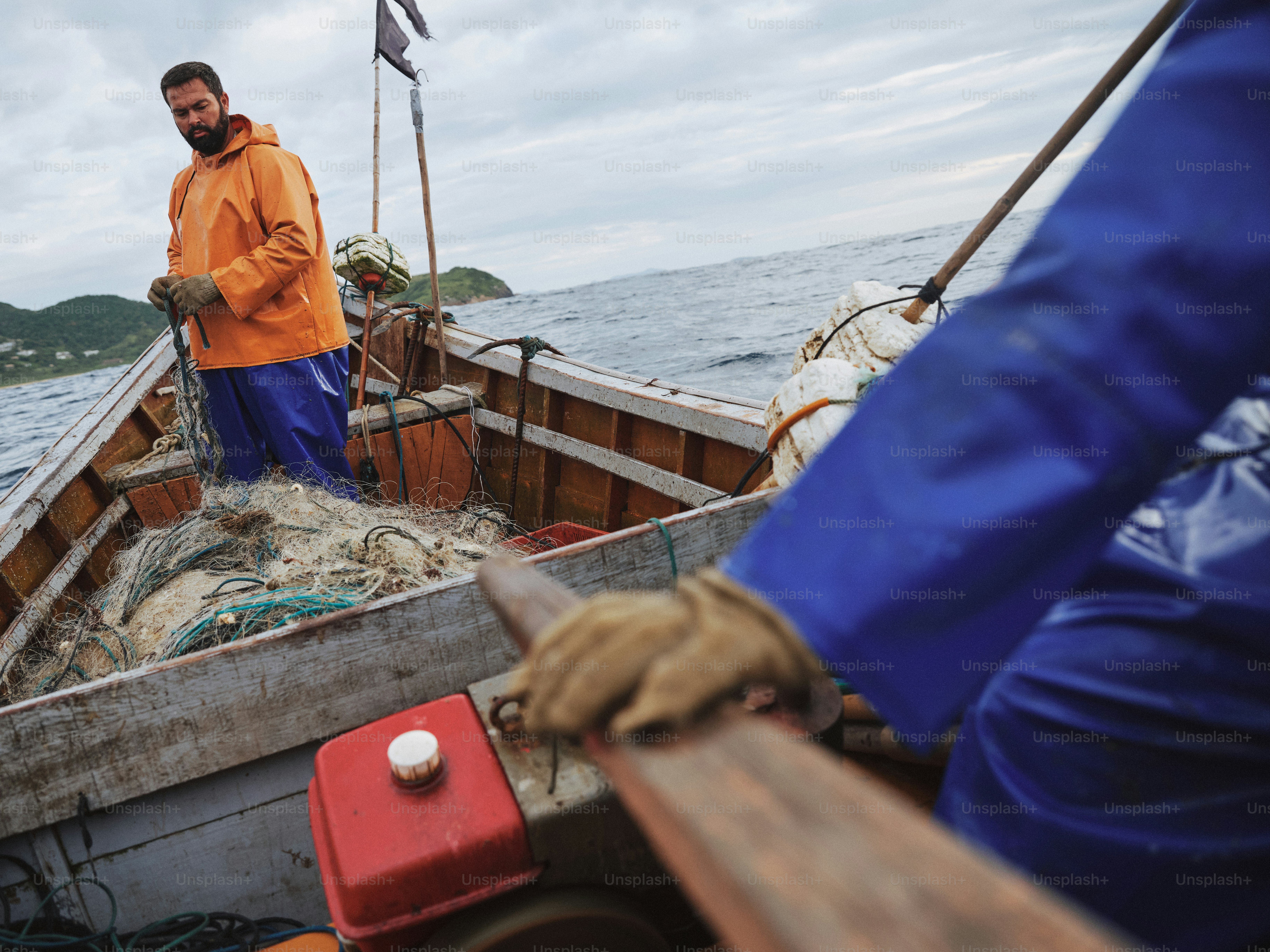 Fishermen on a small boat are working at sea. photo – Fishing Image on ...