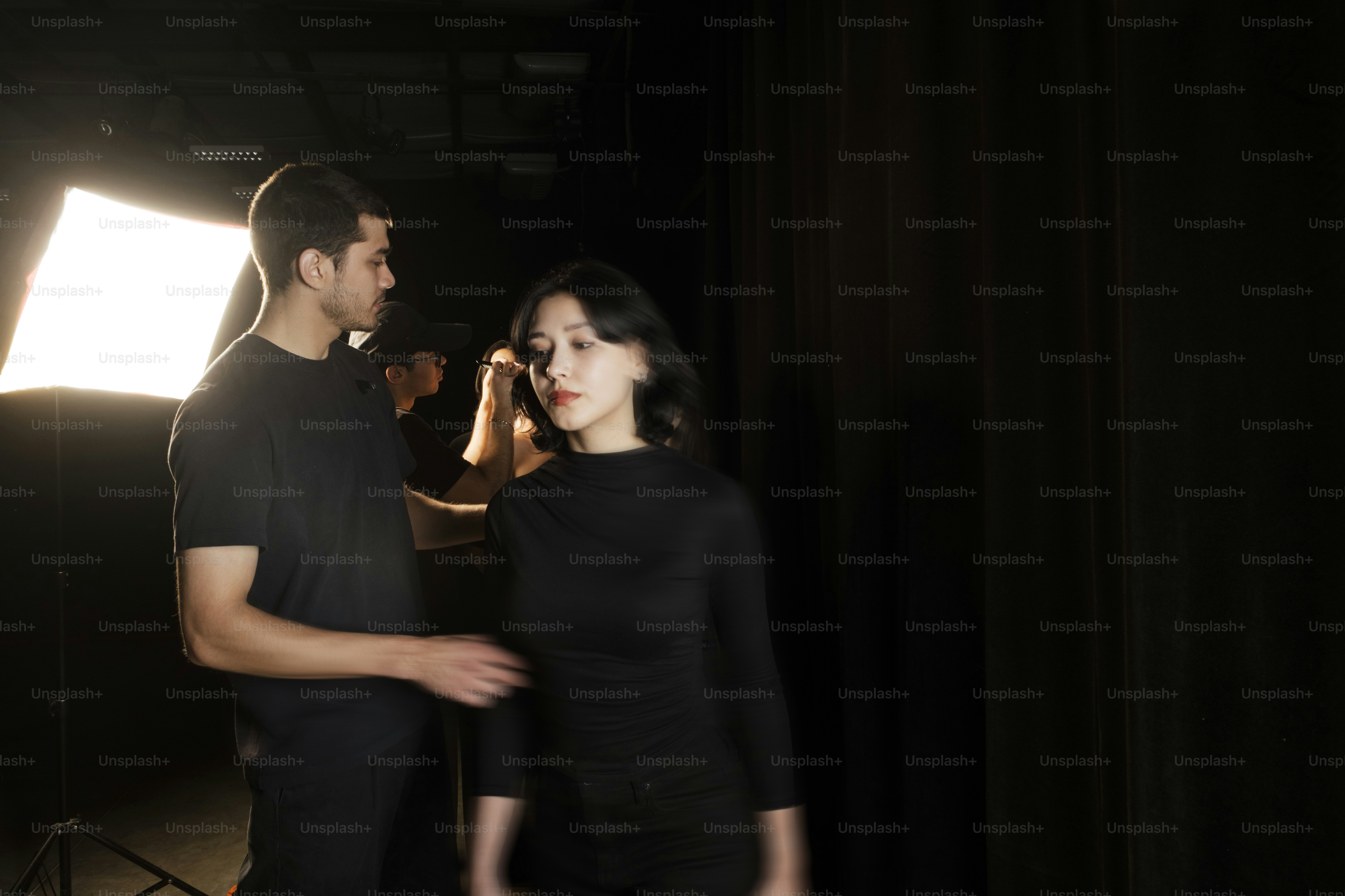 Makeup artists are preparing a model for a photo shoot. photo – Fashion ...