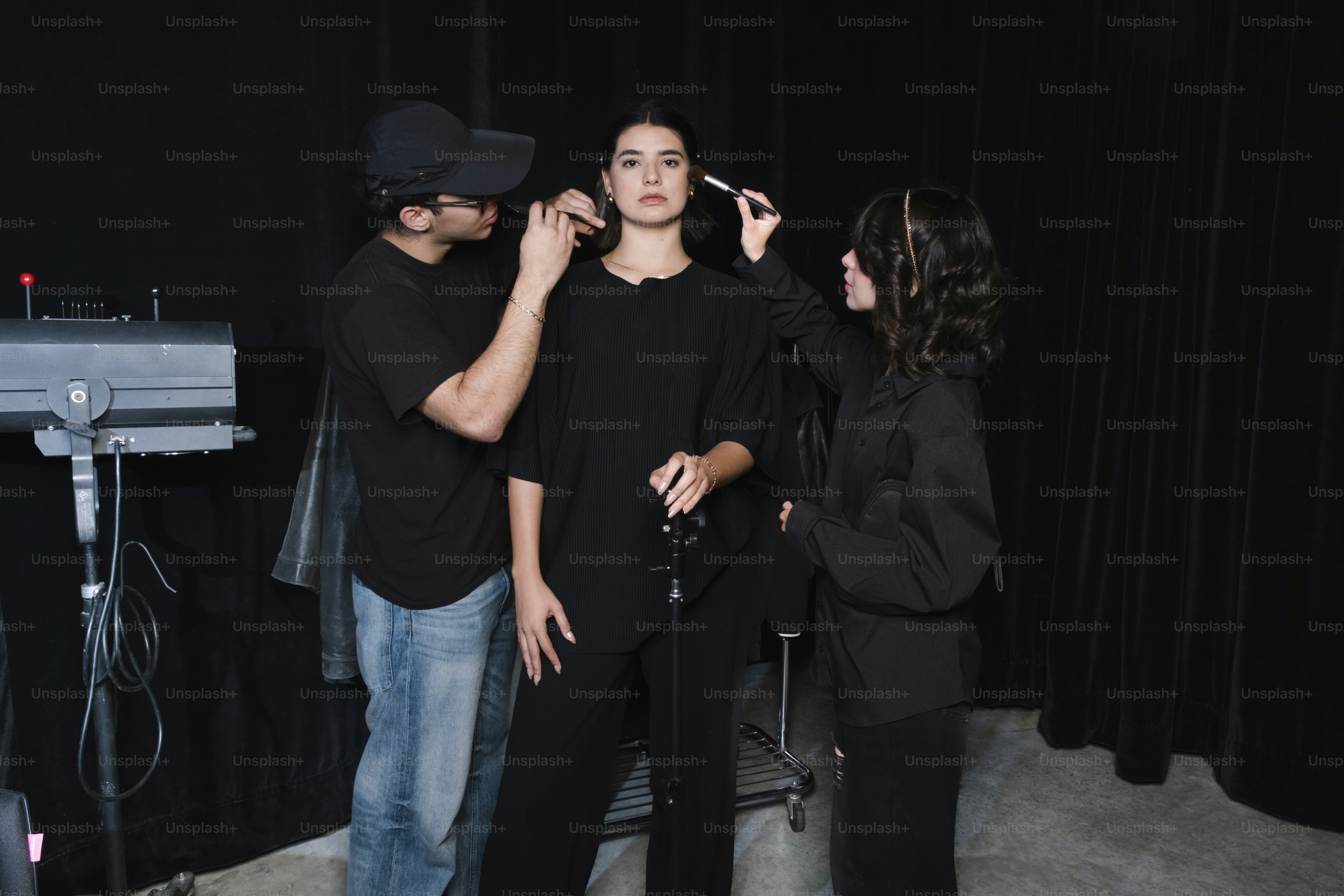 Makeup artists are preparing a model for a photo shoot. photo – Fashion ...