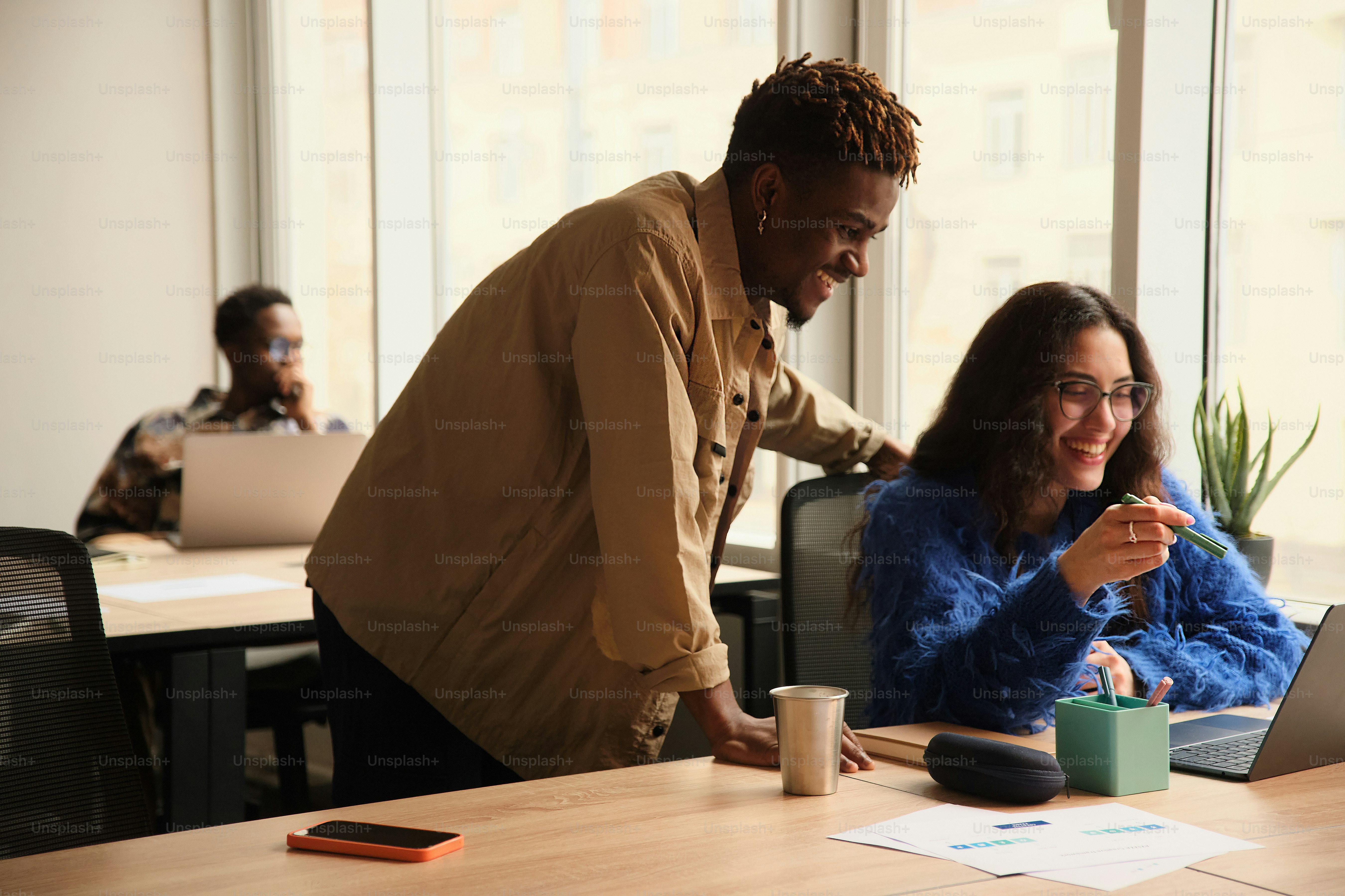 Colleagues collaborating happily at a shared workspace. photo – Team ...