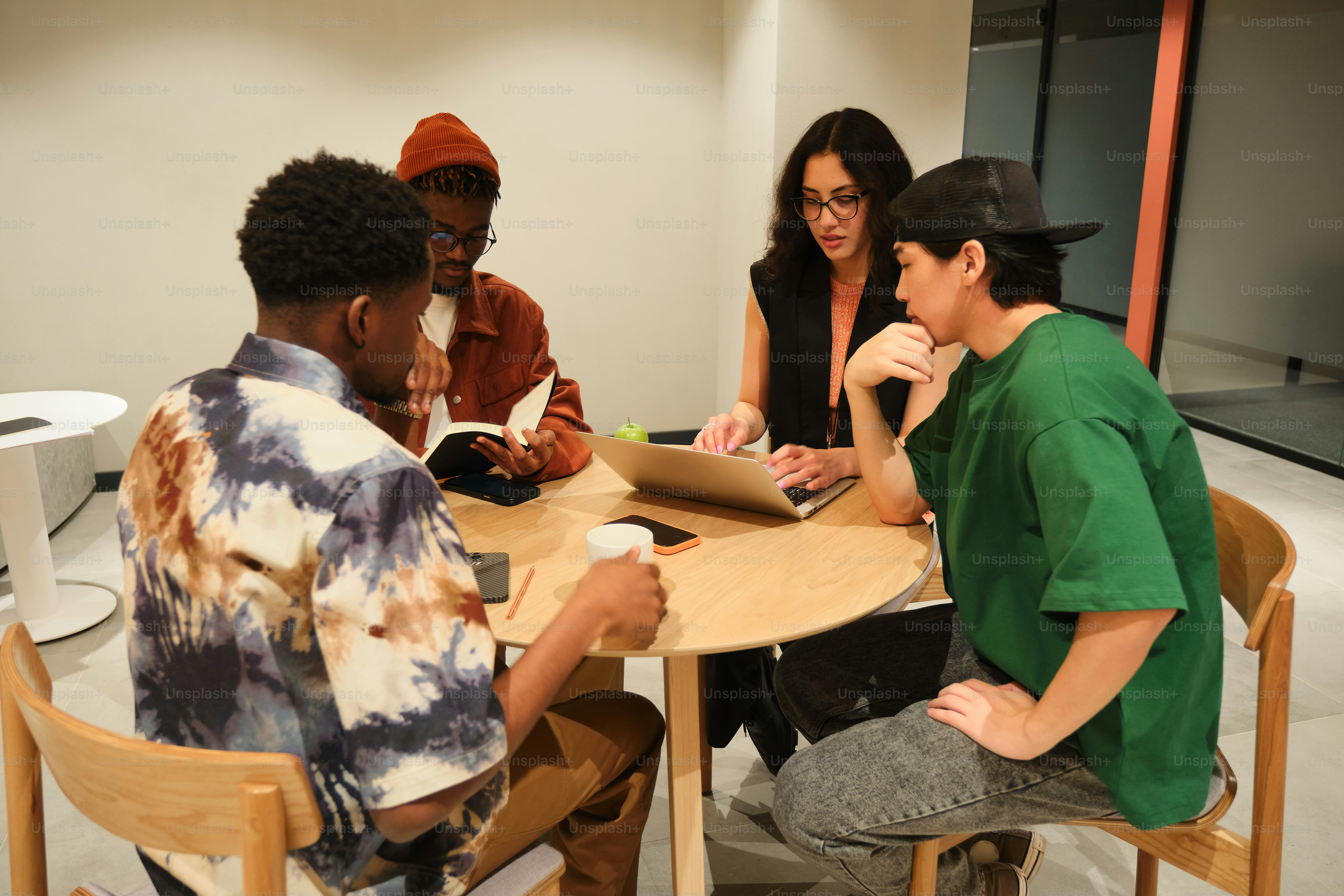 A diverse group collaborates around a table. photo – Team Image on Unsplash