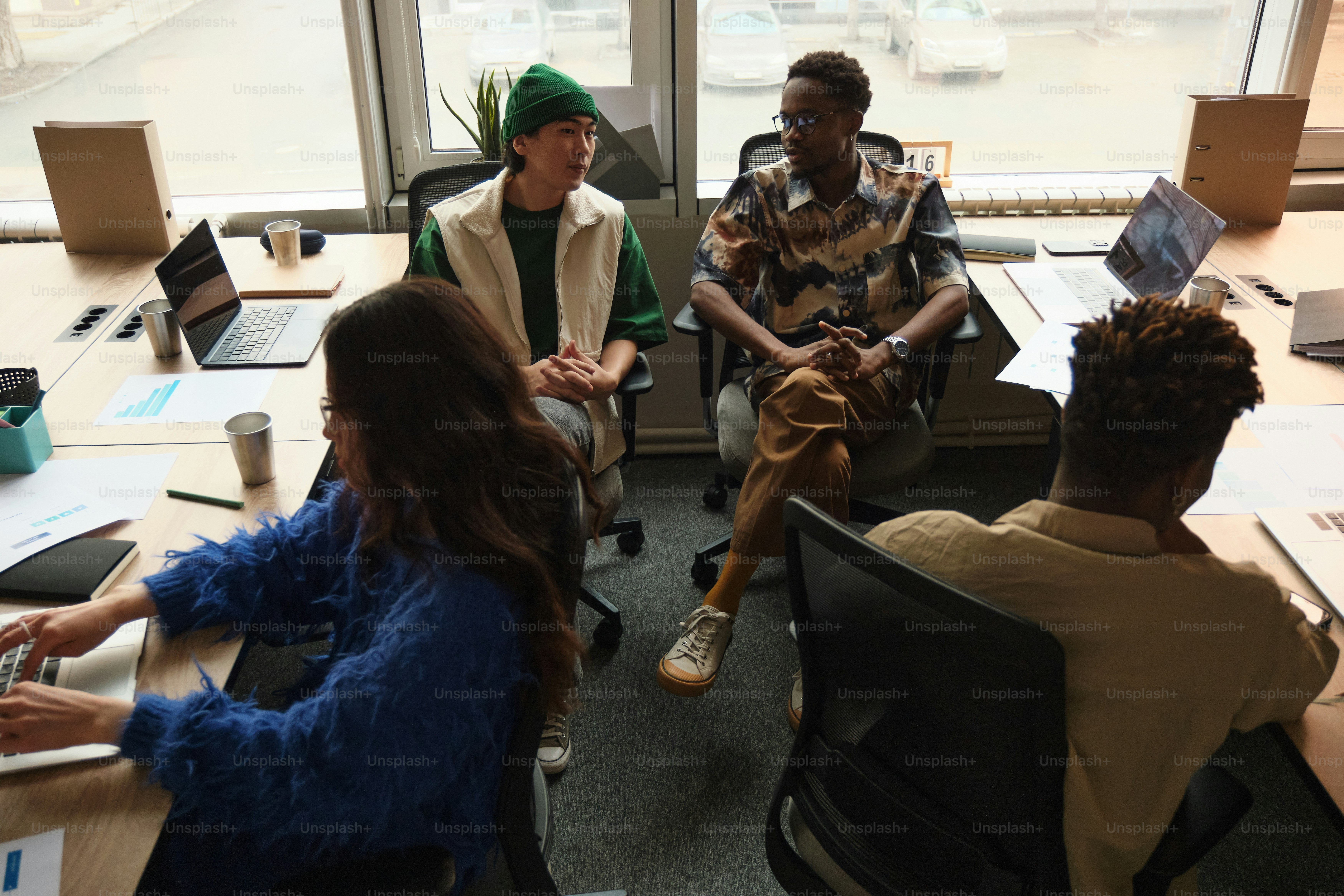 Coworkers collaborate at their desks in the office. photo – Team Image ...