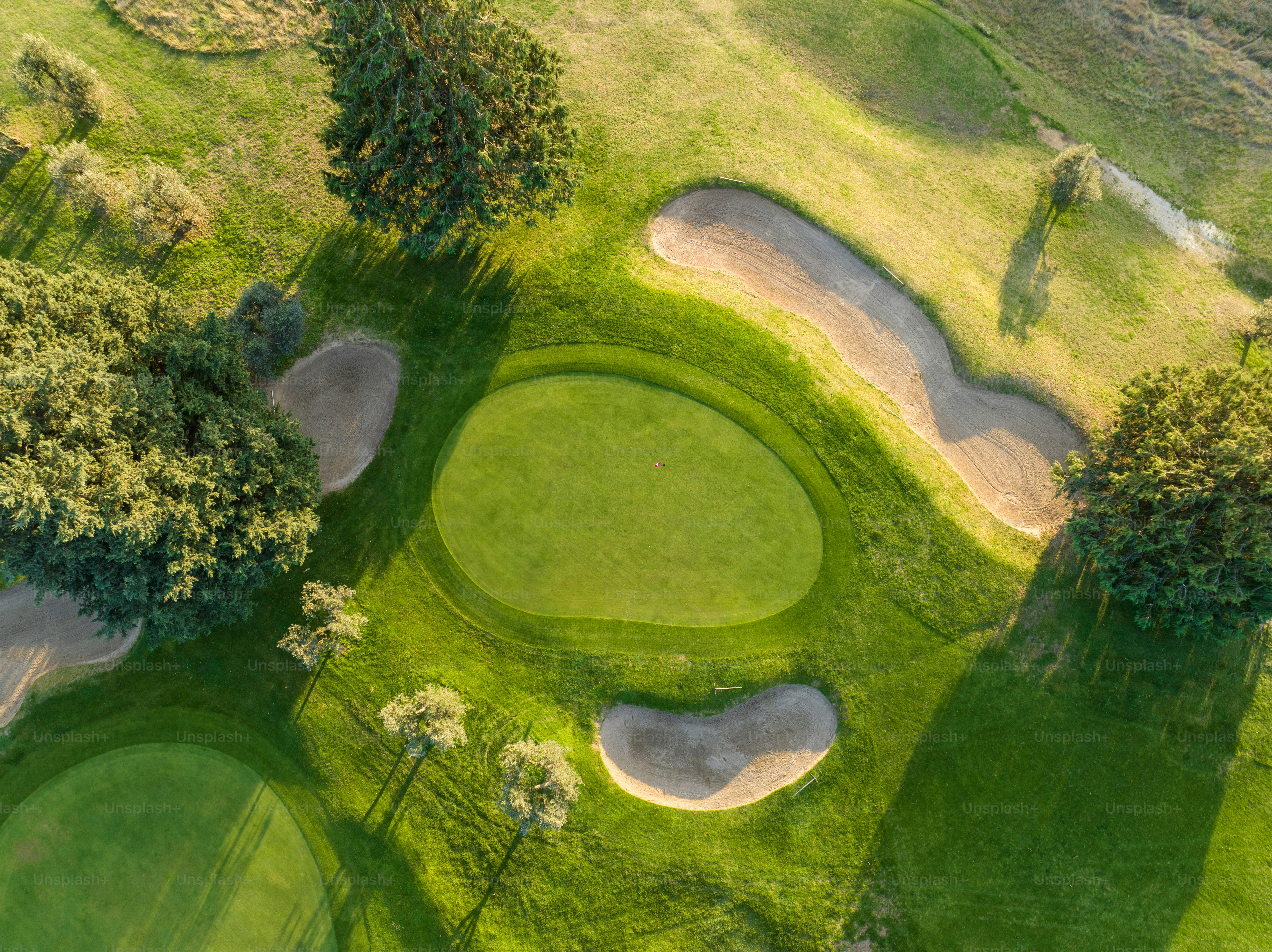 Aerial view of a golf course at sunset. Drone point of view of a golf ...