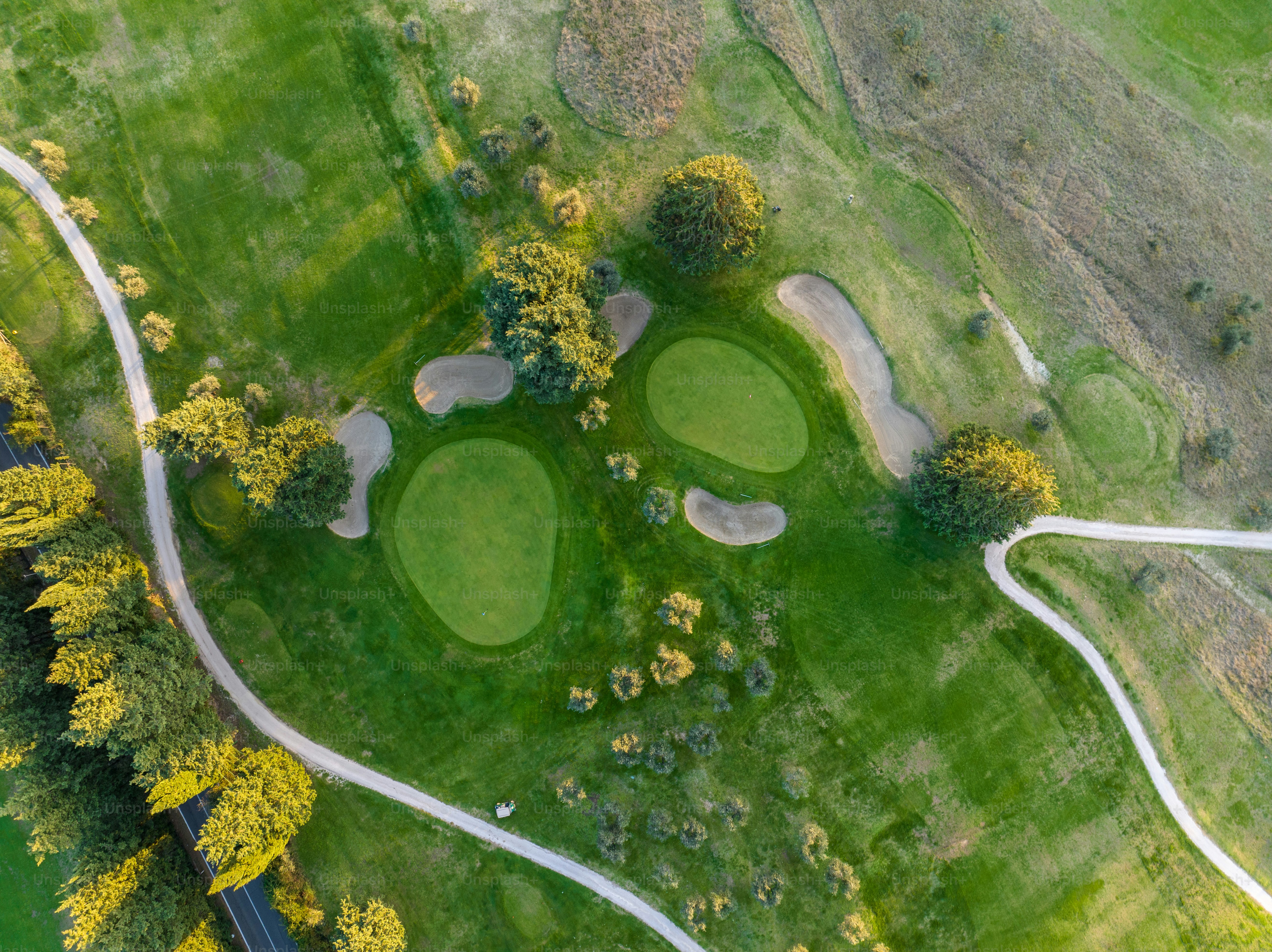 Aerial view of a golf course at sunset. Drone point of view of a golf ...