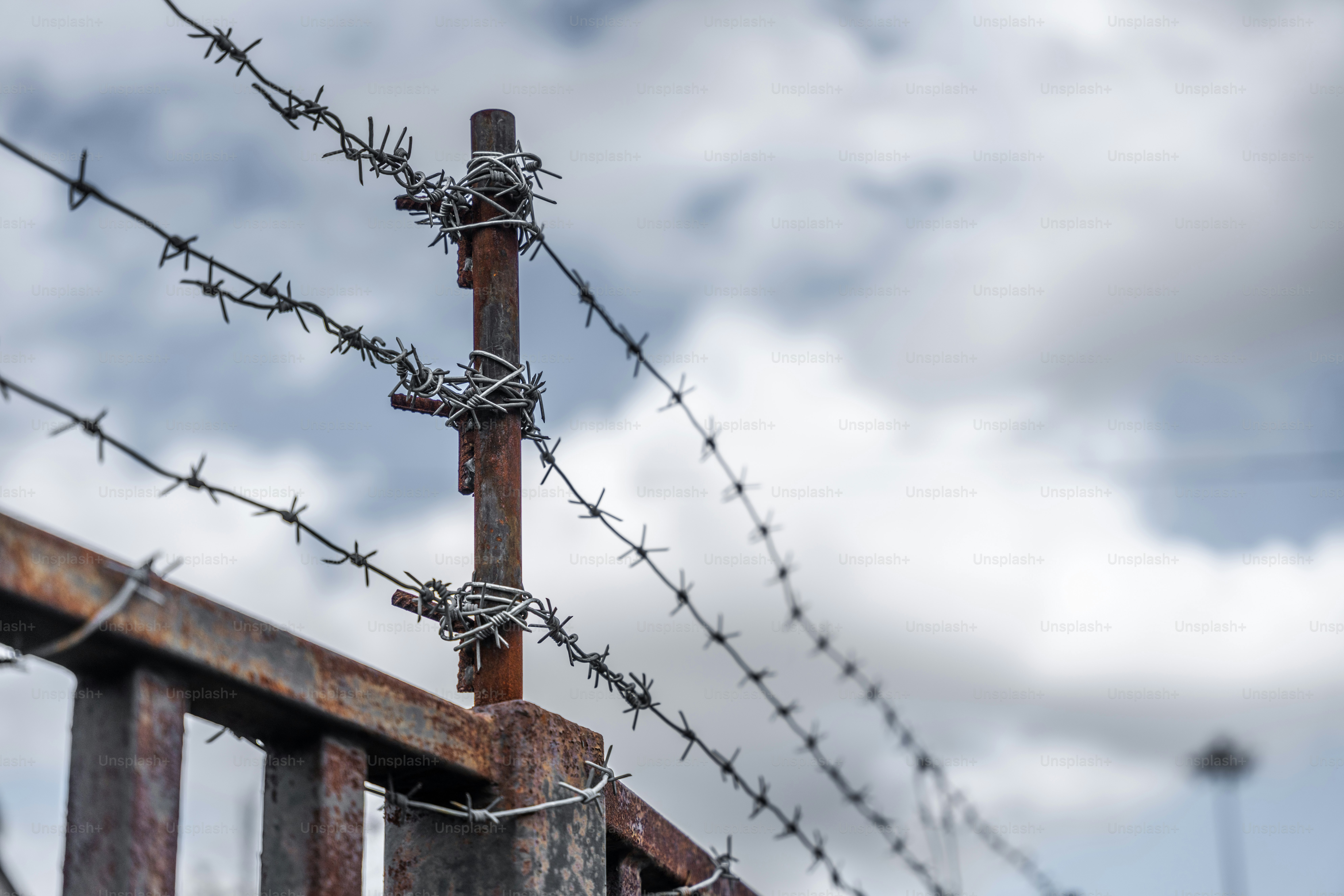 A prison or border fence with barbed wire on the top photo – Abstract ...