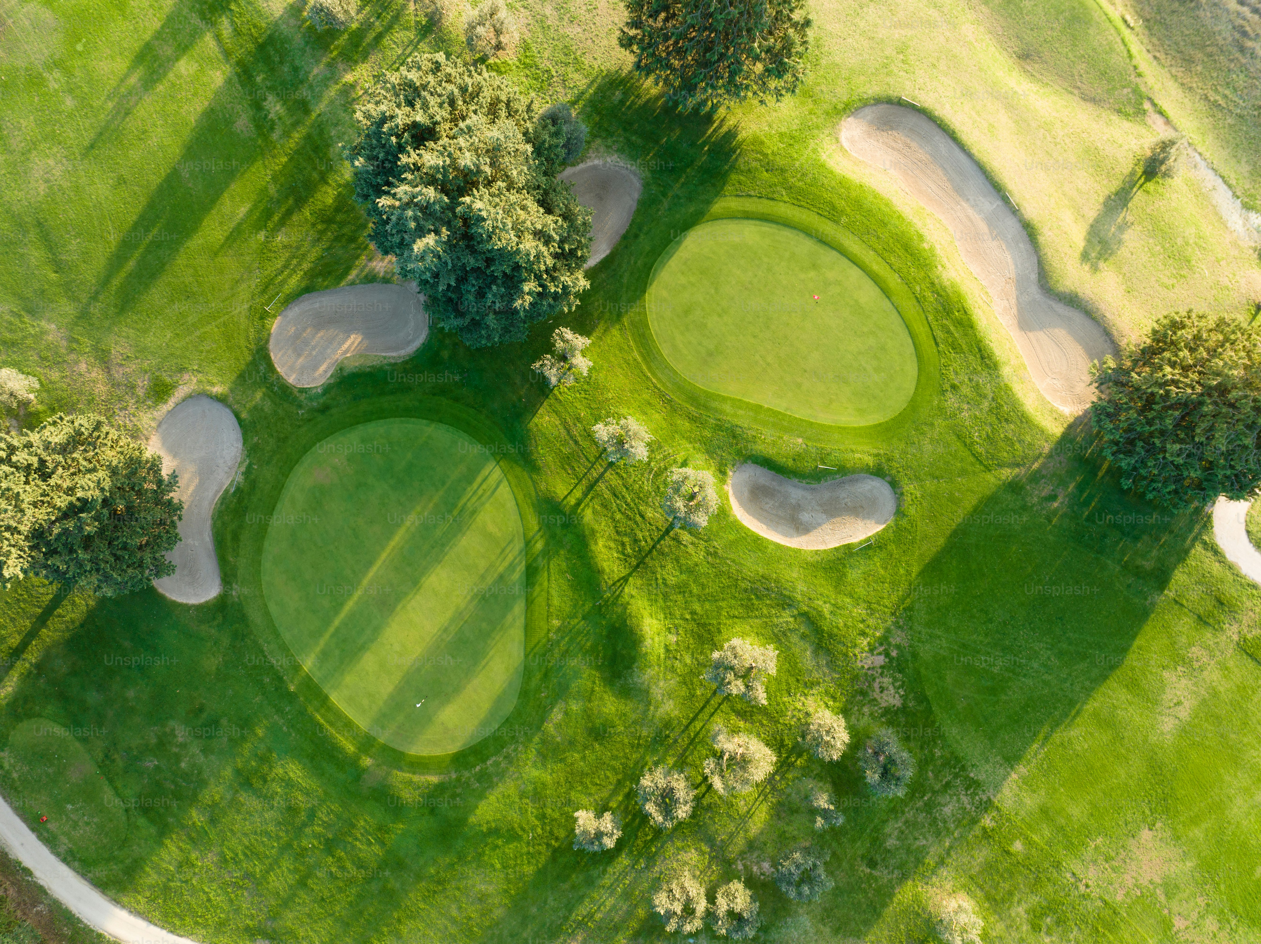 Aerial view of a golf course at sunset. Drone point of view of a golf ...