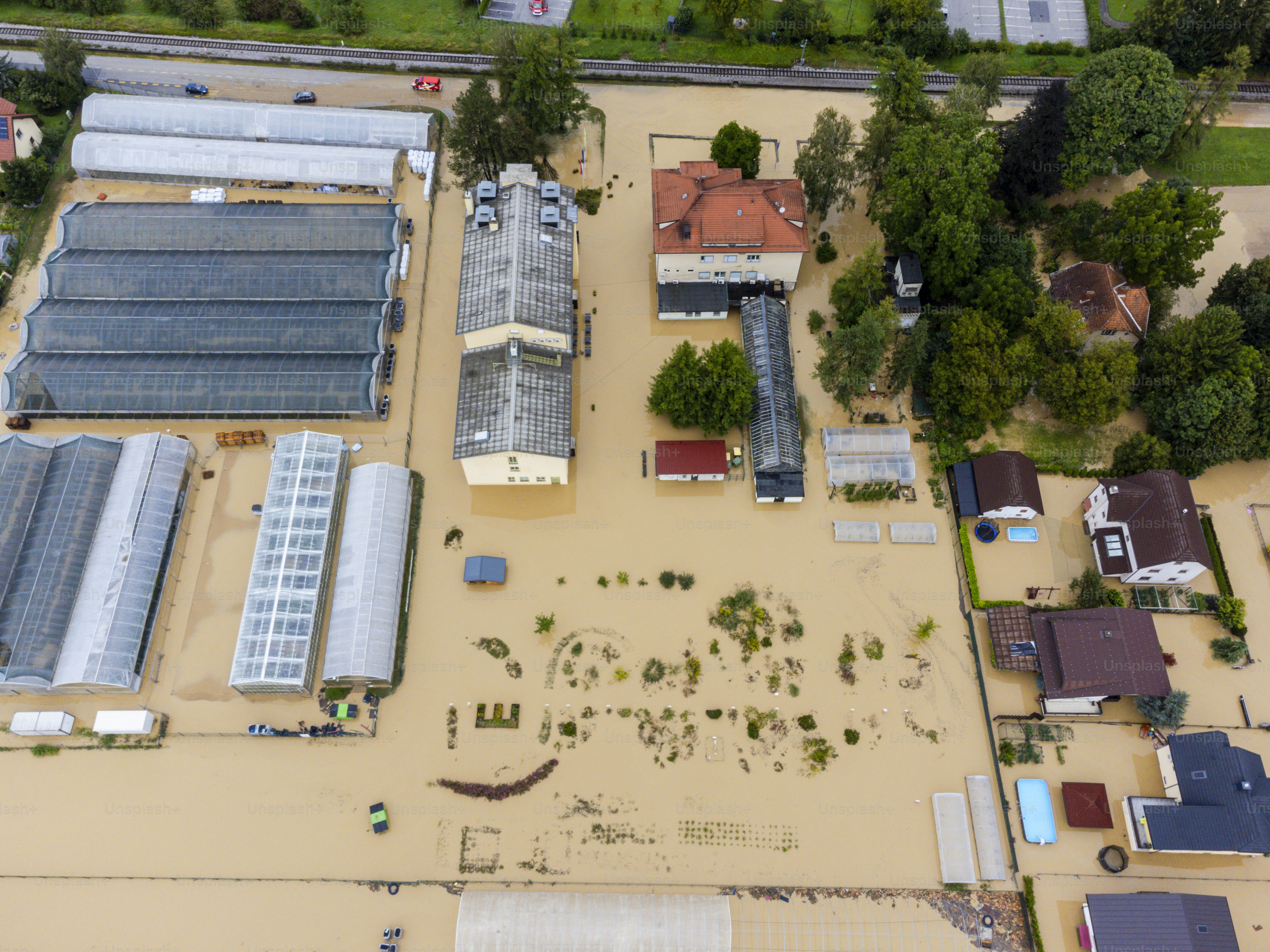 Aerial view of flooded farmland with submerged fields and trees, showcasing the impact of ...