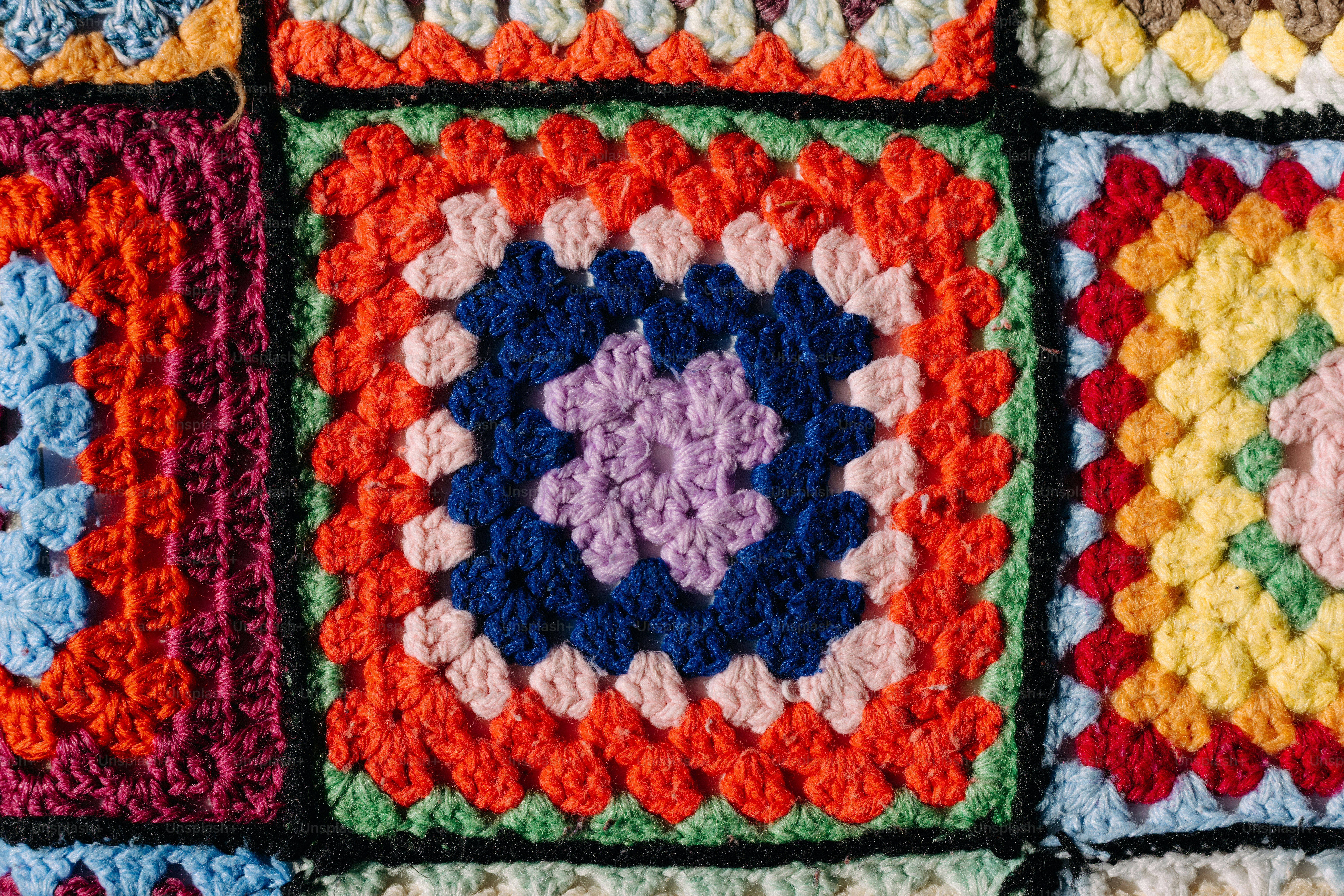 Colorful crocheted squares make up a blanket. photo – Colourful Image ...