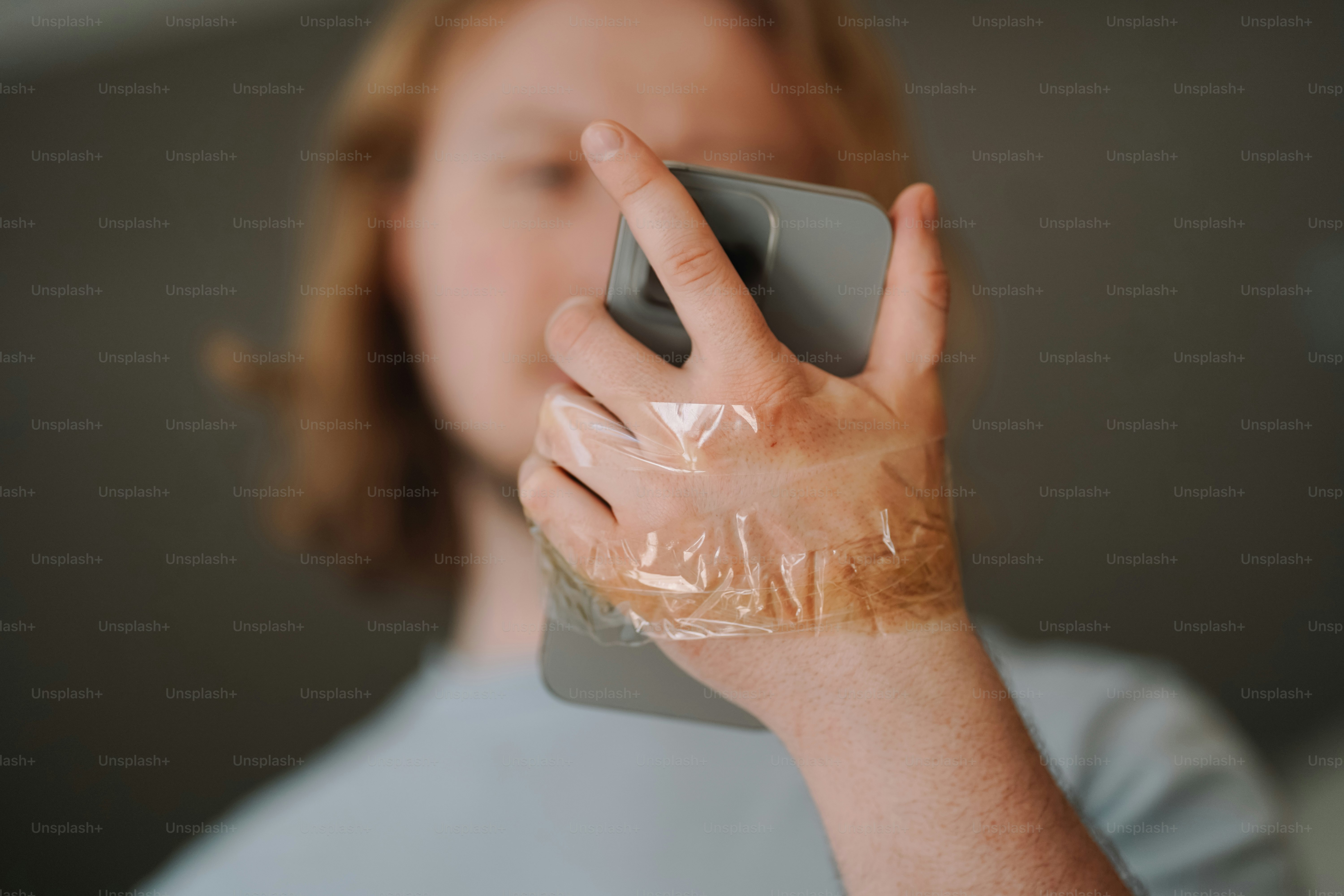 A man with a taped hand uses his phone. photo – Technology Image on ...
