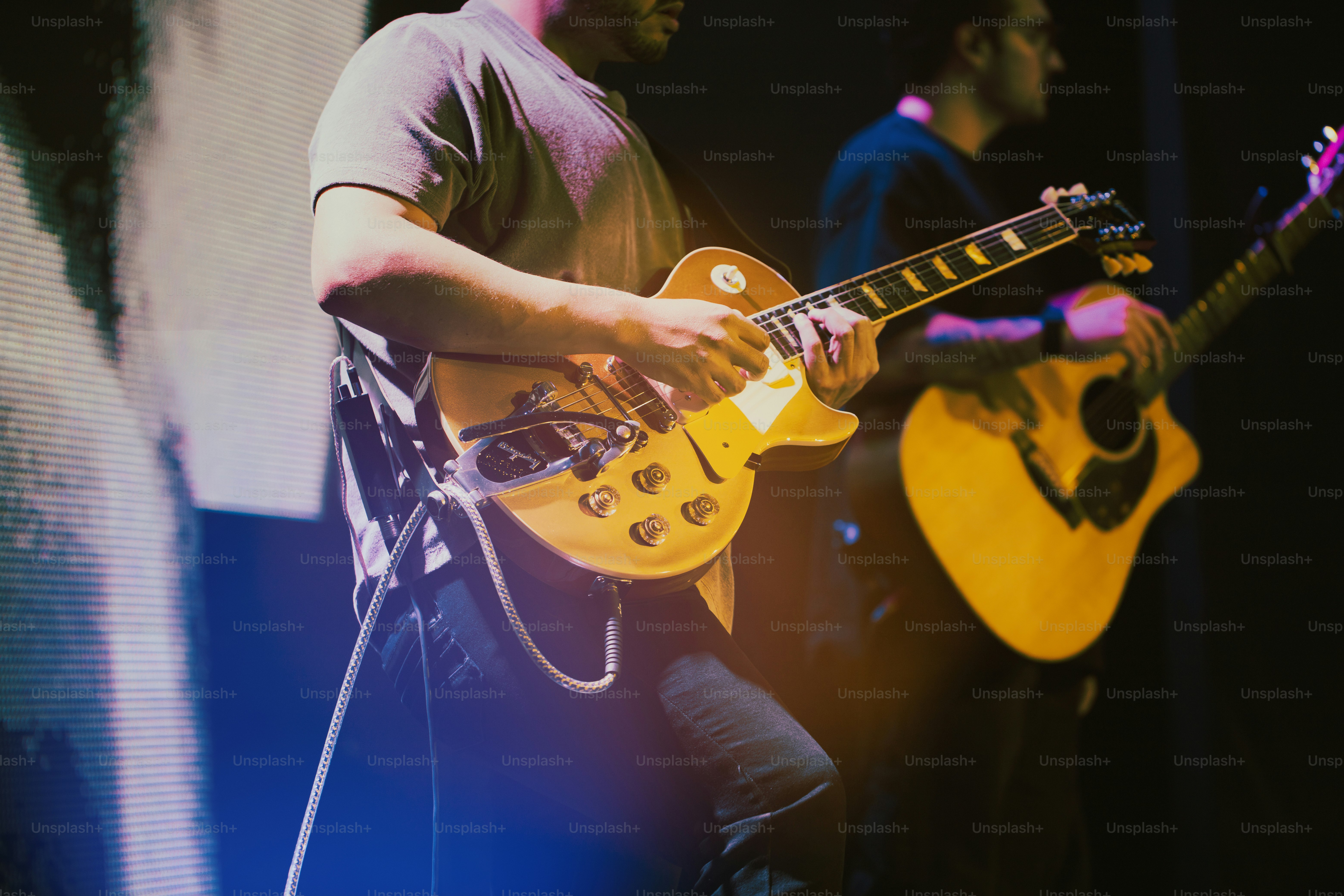 Músicos tocando guitarras en un escenario oscuro. foto – Imagen de ...