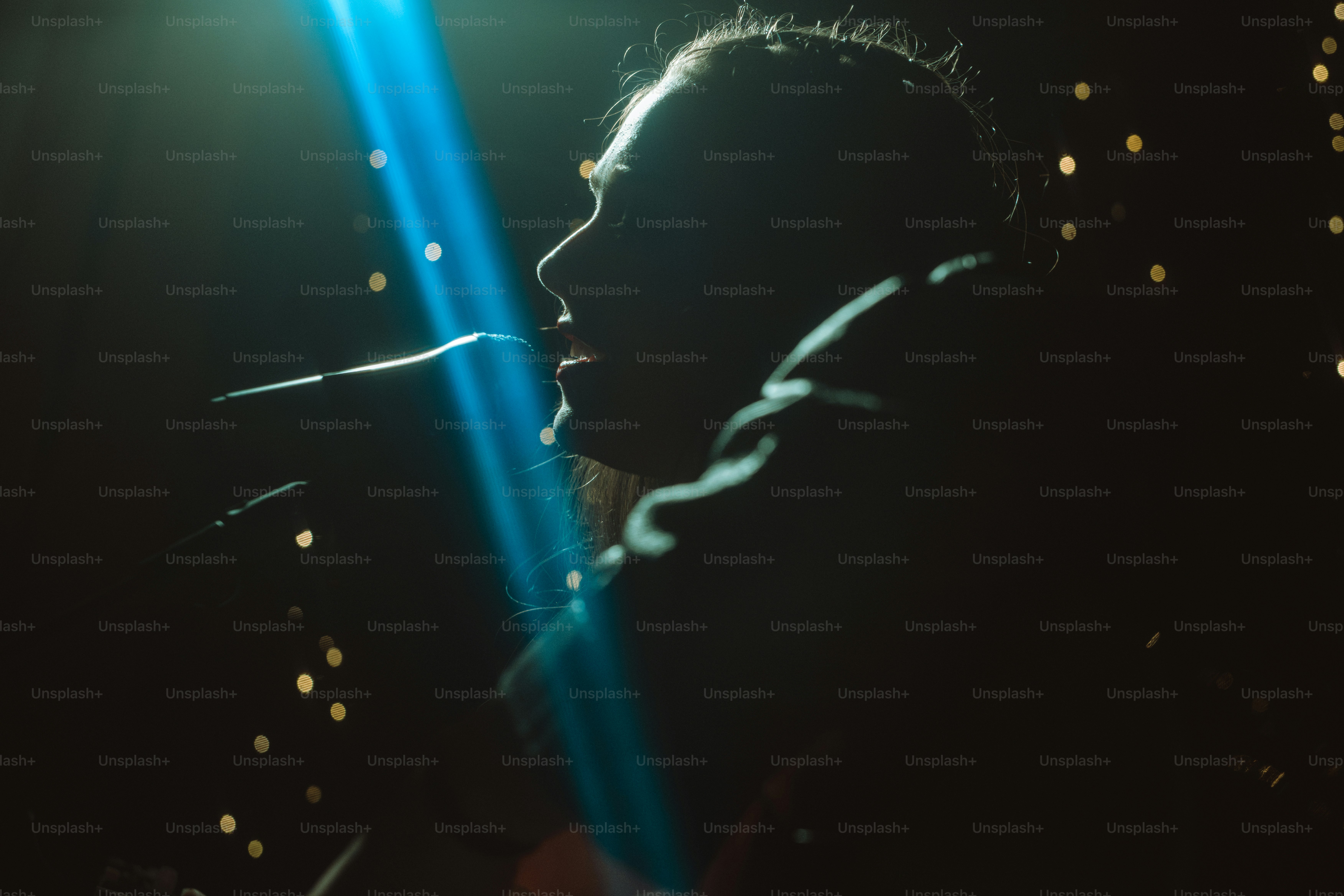 Singer on stage in a beam of light. photo – Music Image on Unsplash