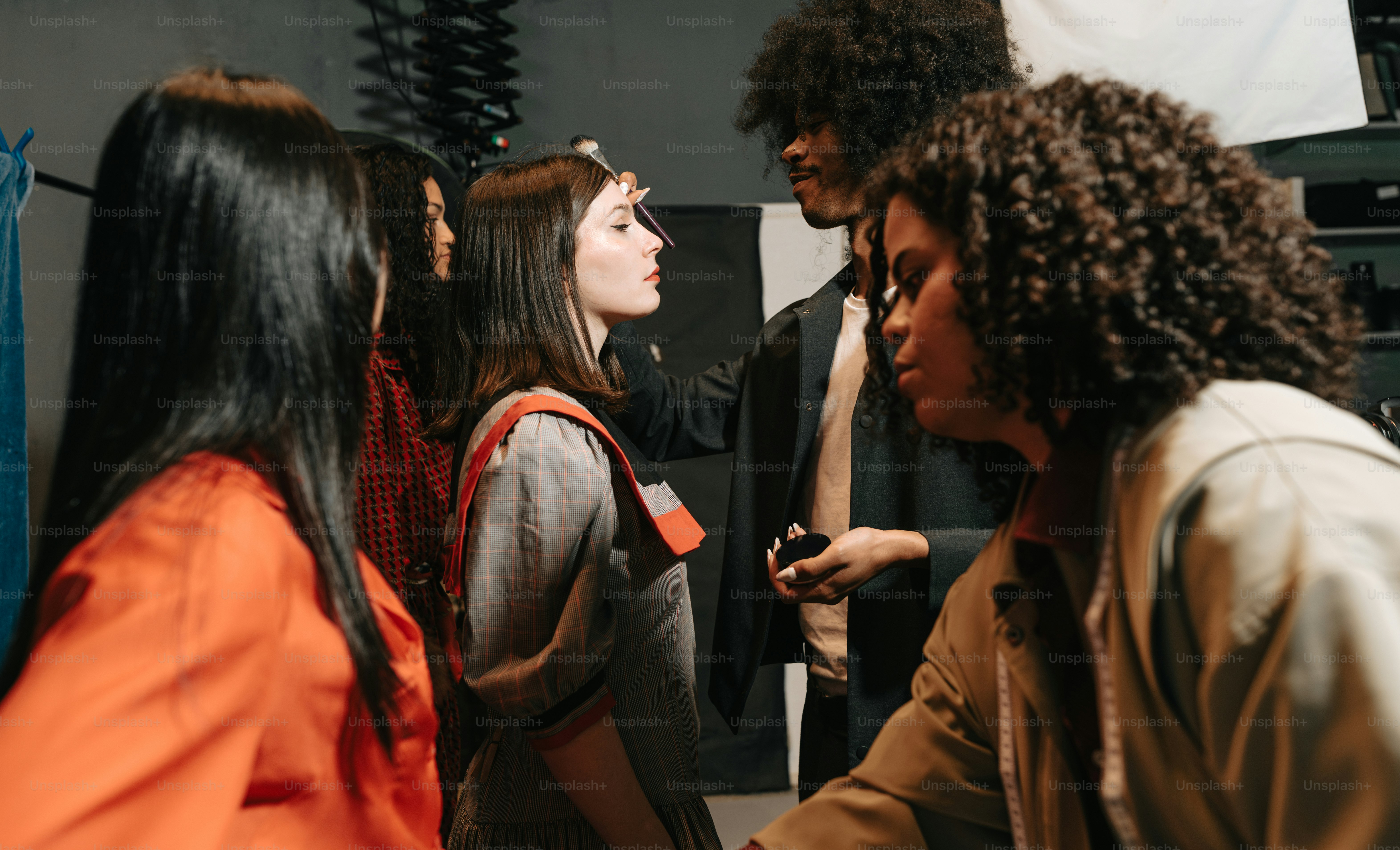 Las modelos y el equipo se preparan en el backstage para una sesión de ...