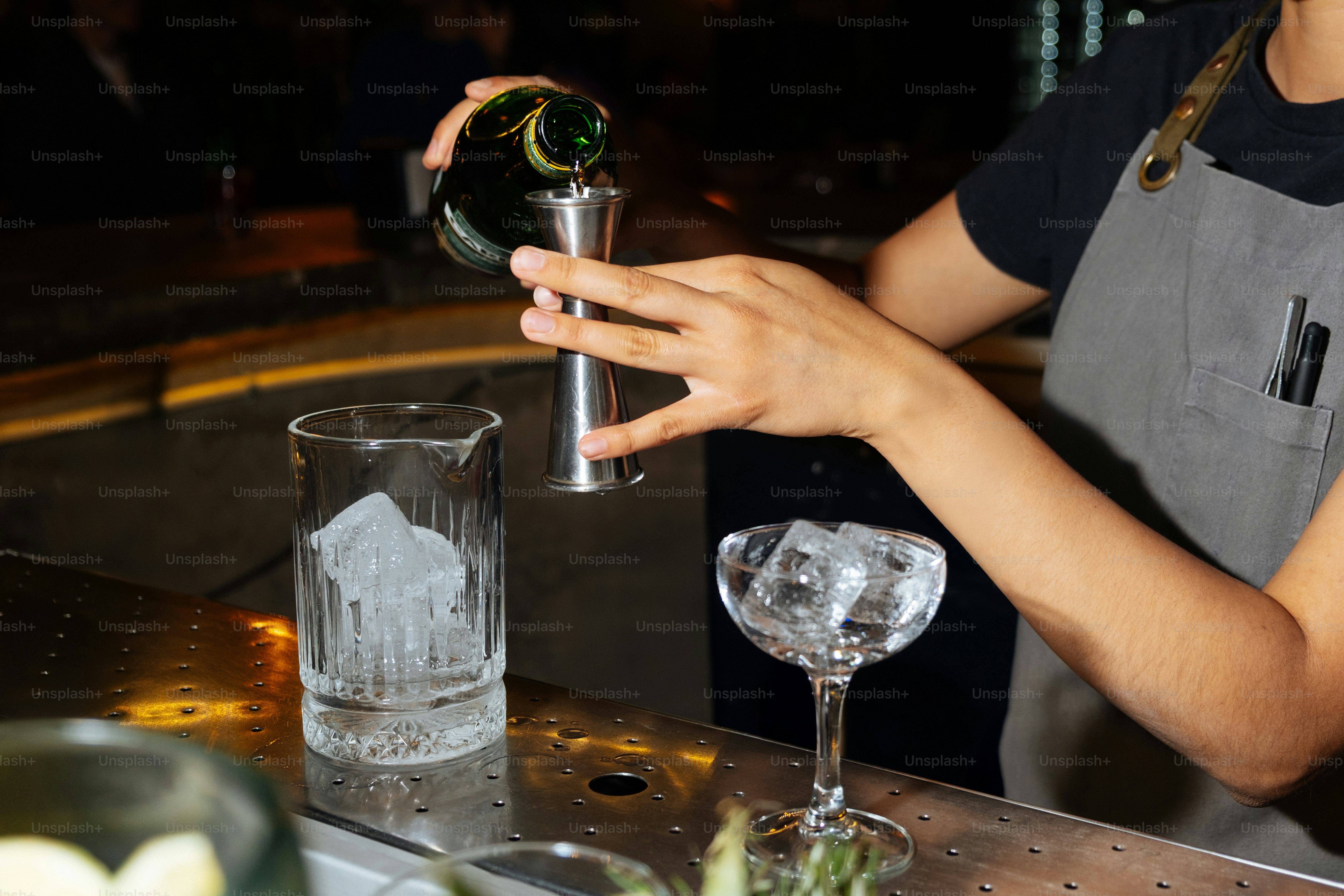 A bartender pours a drink into a jigger. photo – Cocktails Image on ...