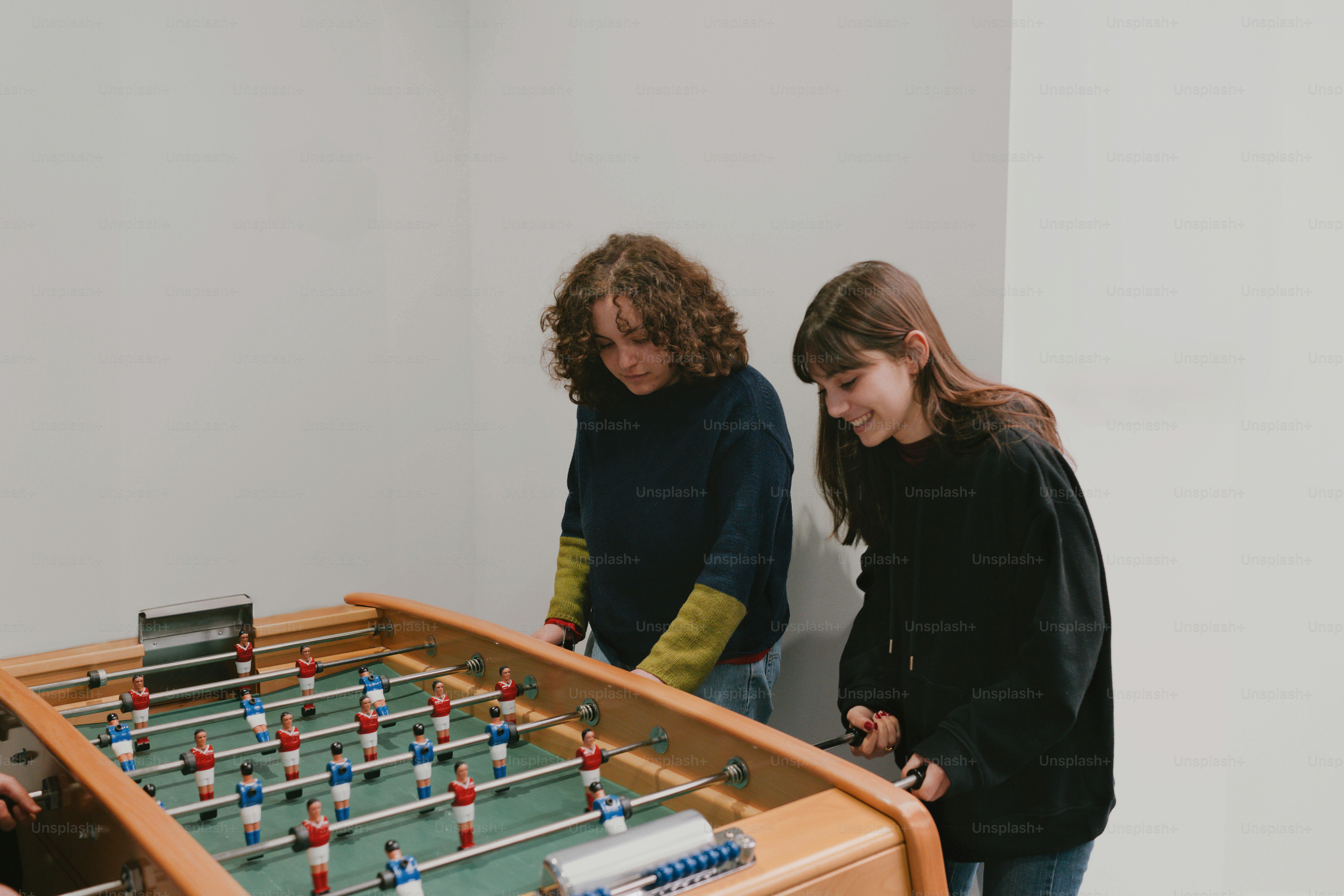 Two people are playing foosball together. photo – Office Image on Unsplash
