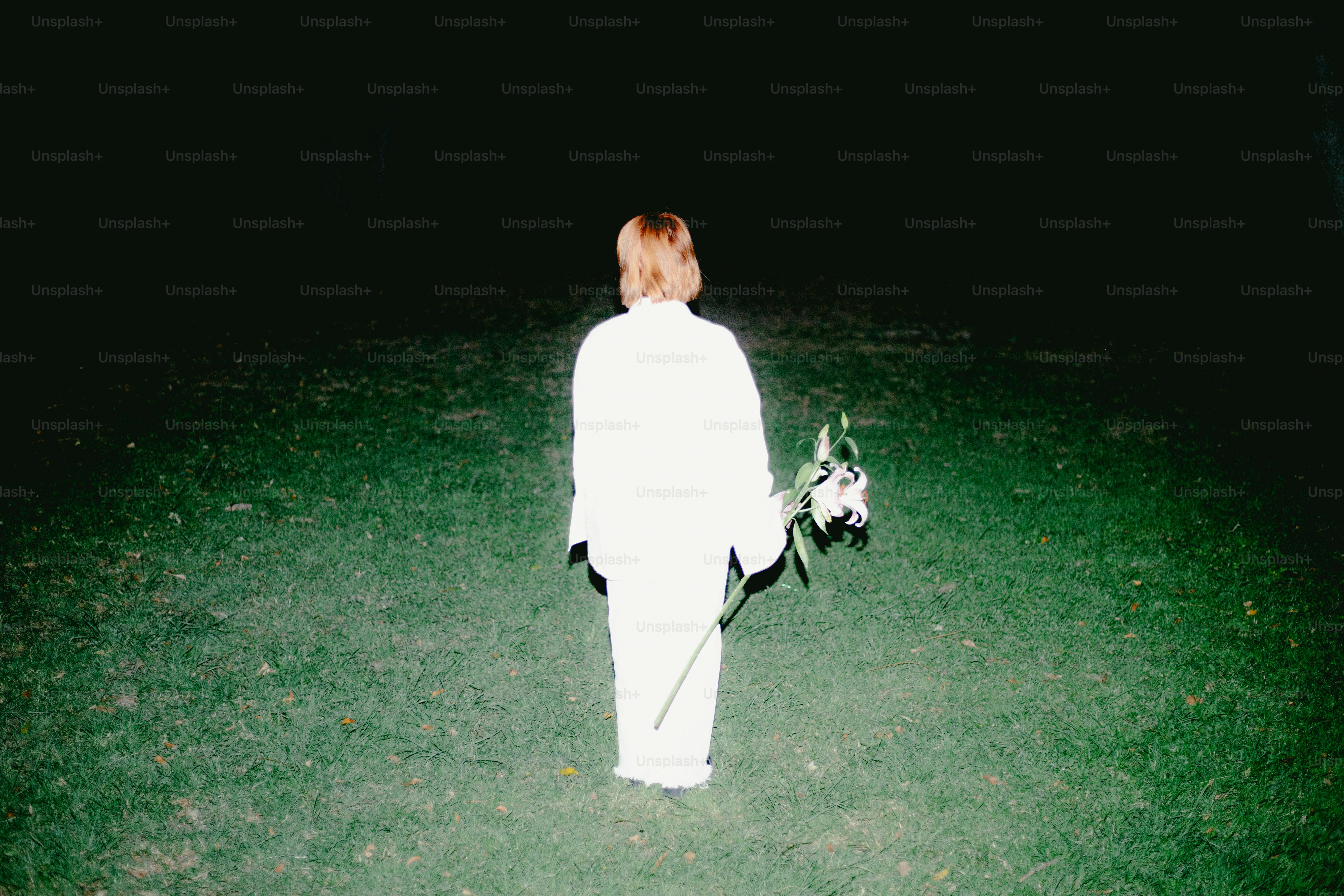 A person walks alone at night, holding flowers. photo – Flash Image on ...