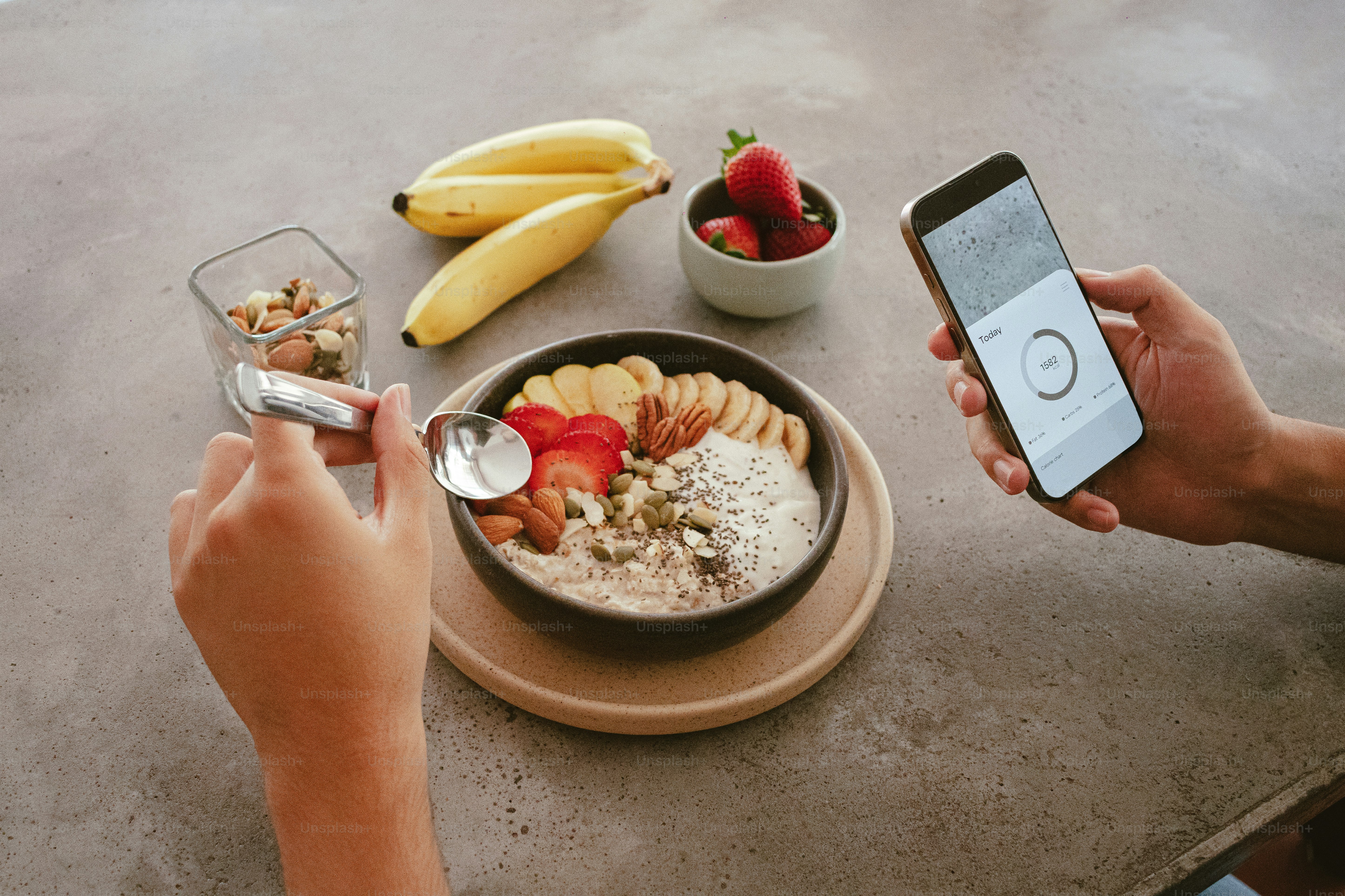 Someone is eating a healthy breakfast and using their phone. photo ...
