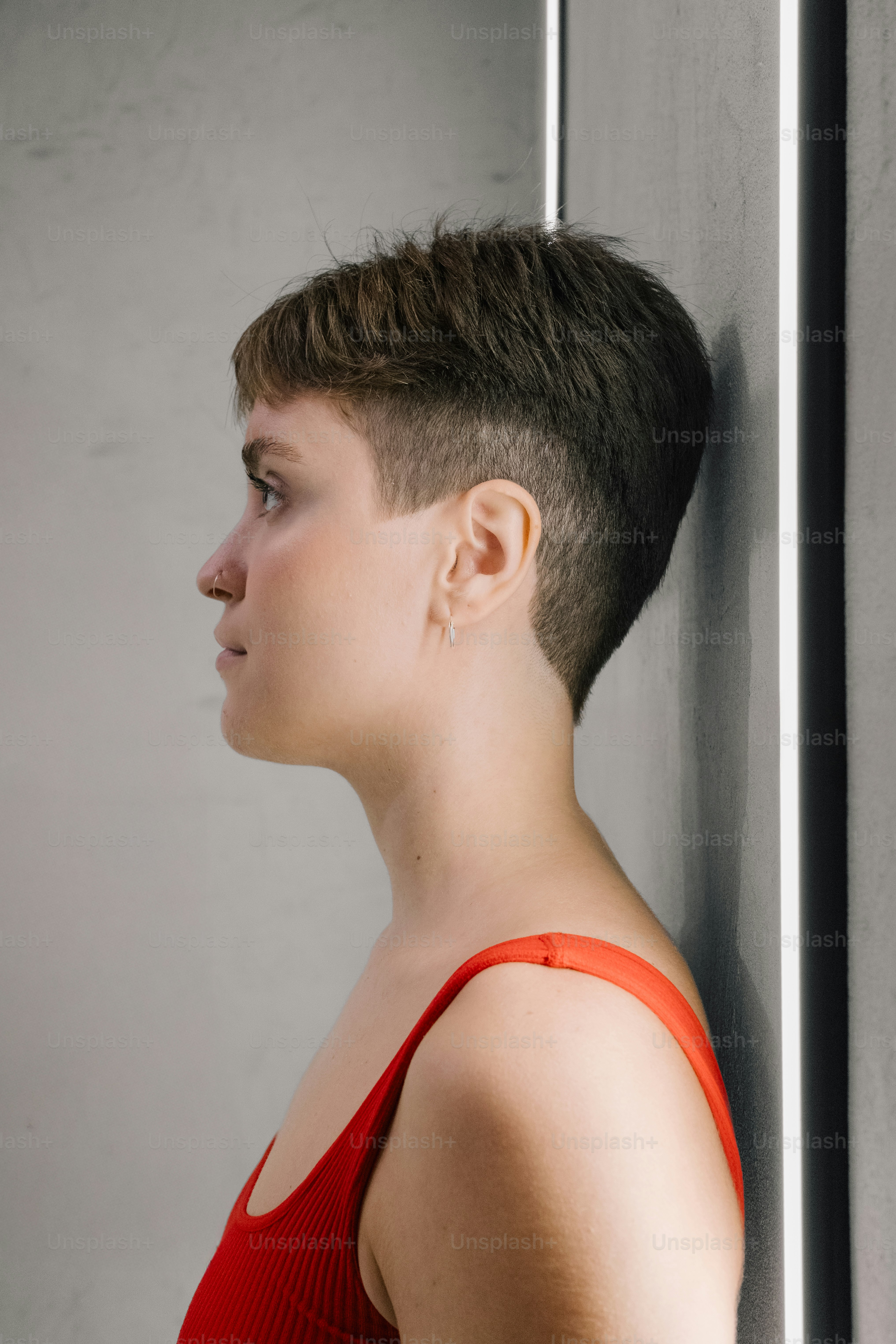 Woman poses sideways, leaning against a wall. photo – Portrait Image on ...
