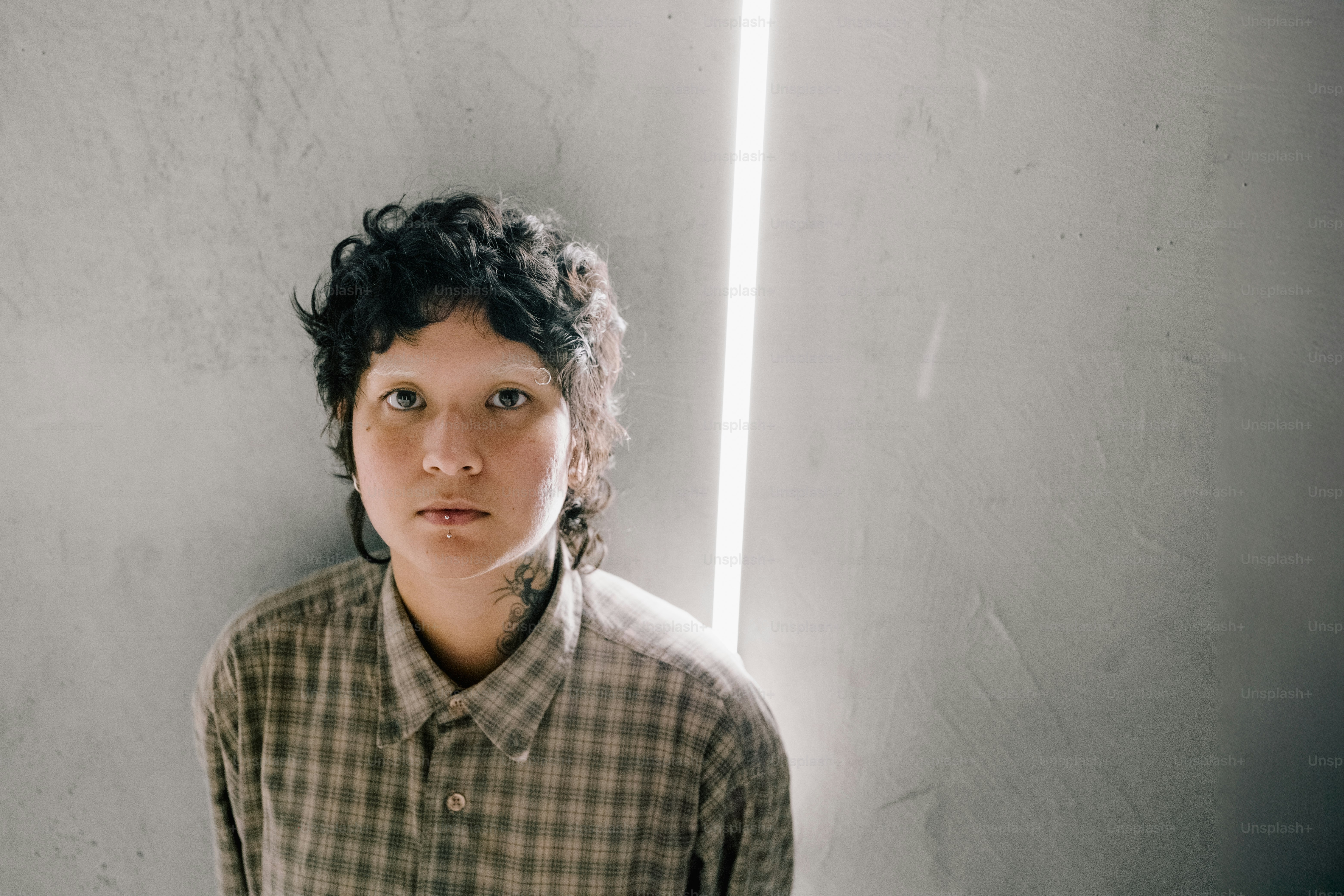 A person poses next to a light fixture. photo – Portrait Image on Unsplash
