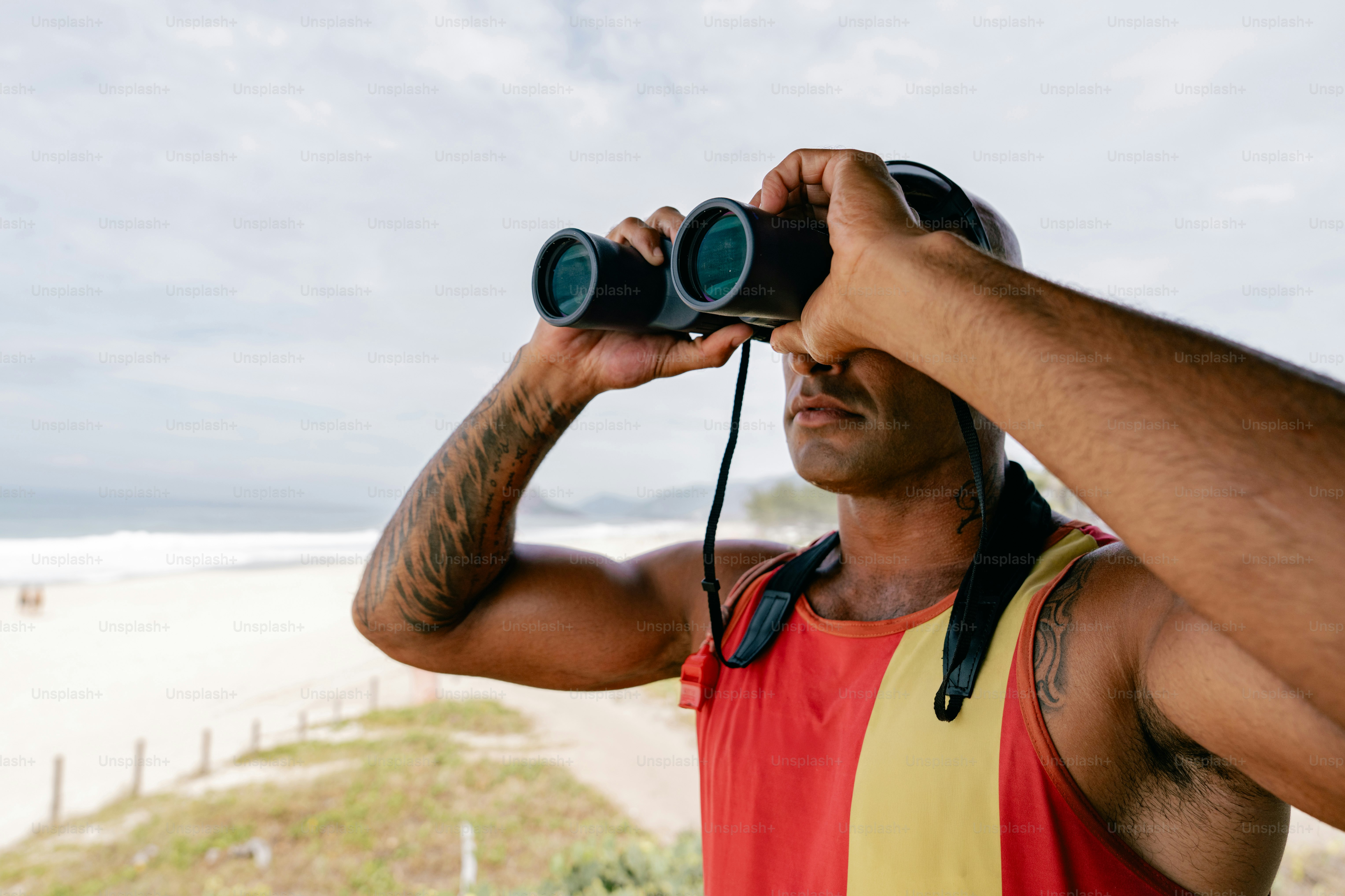 A lifeguard scans the beach with binoculars. photo – Beach Image on ...