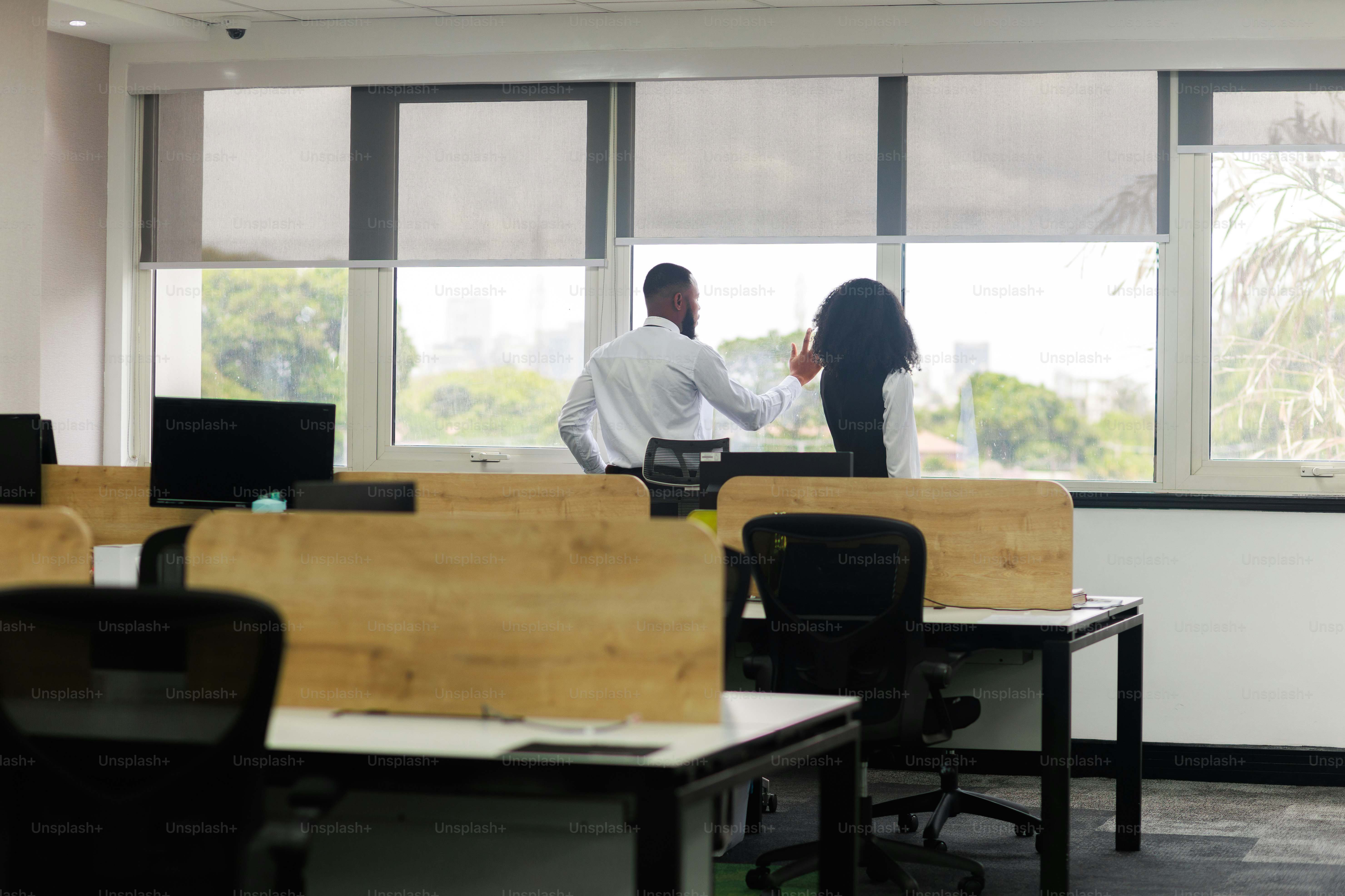 Two colleagues converse near a window in an office. photo – Law Image ...