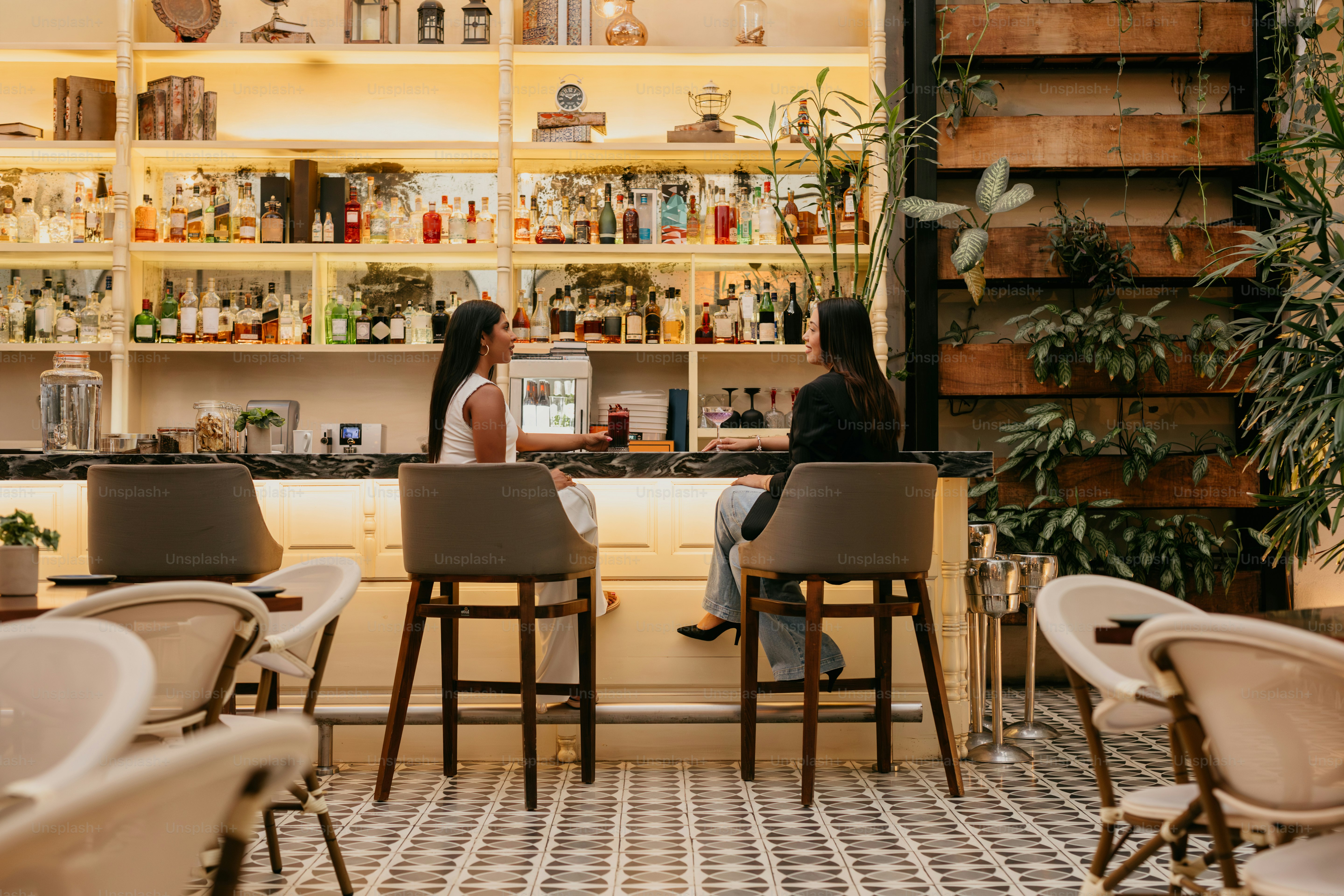 Two women sit at a bar in a stylish interior. photo – Bar Image on Unsplash