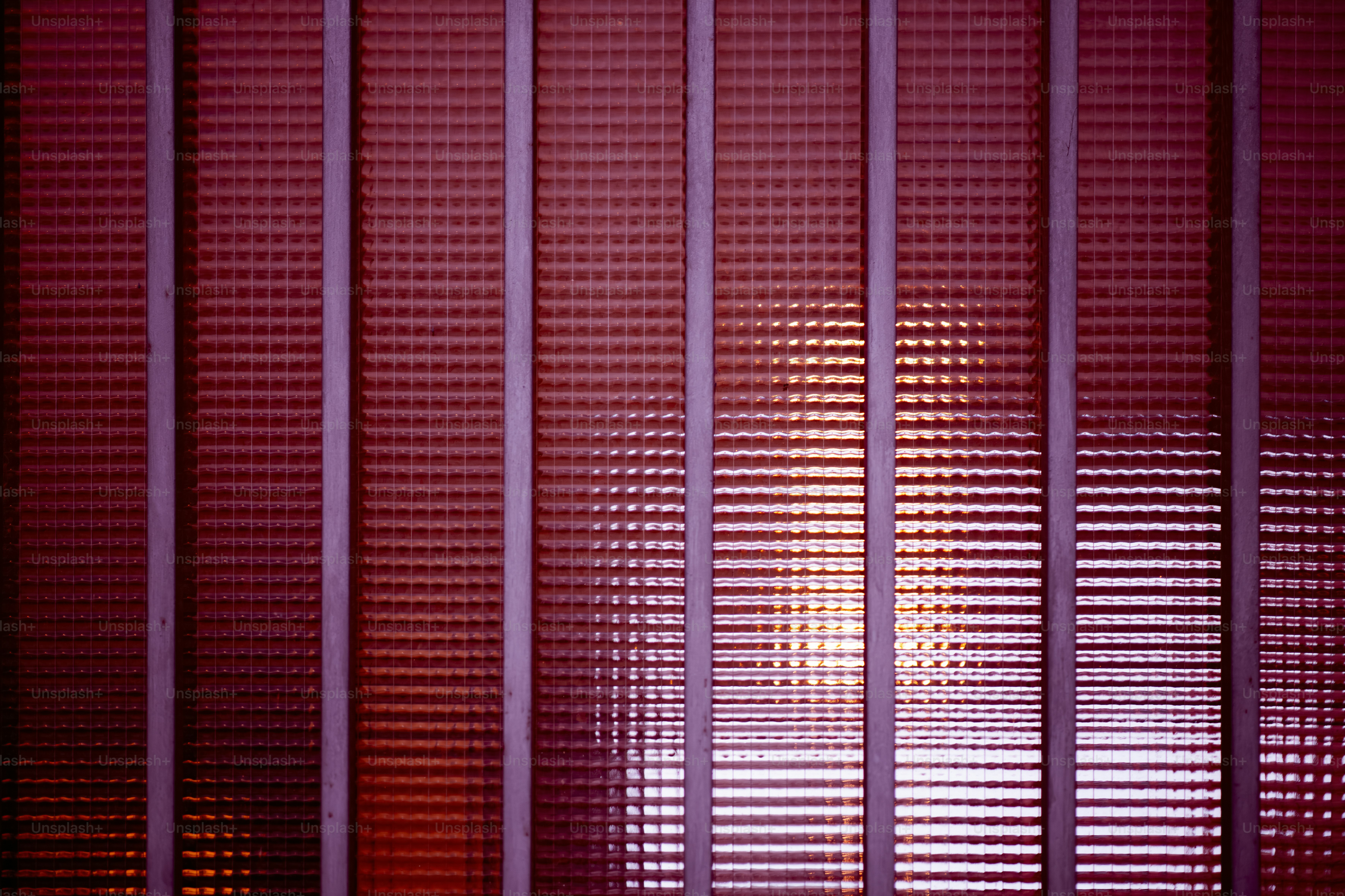 Red bars obscure a blurry light. photo – Background Image on Unsplash