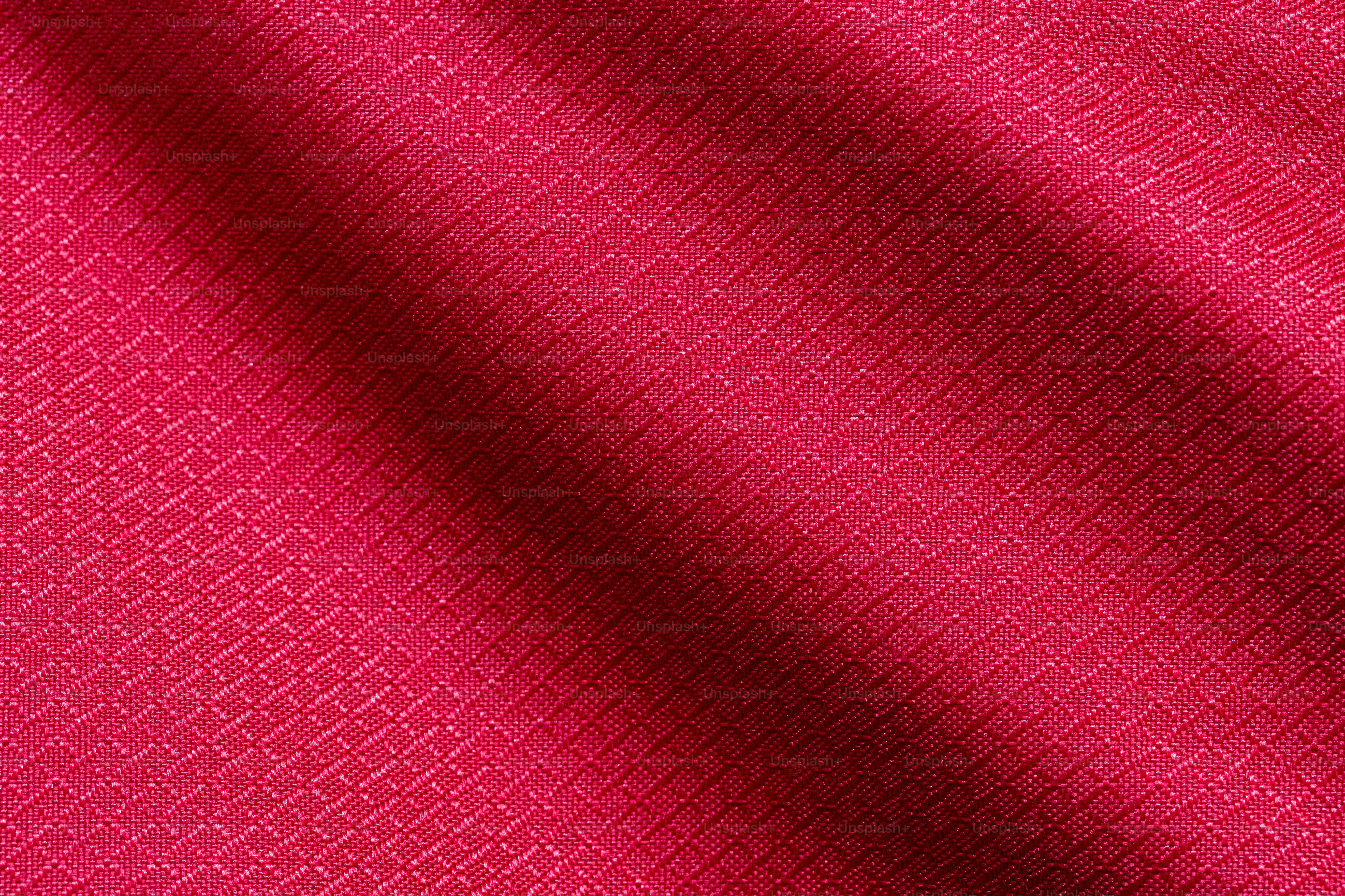 A close-up shot shows vibrant red fabric. photo – Texture Image on Unsplash