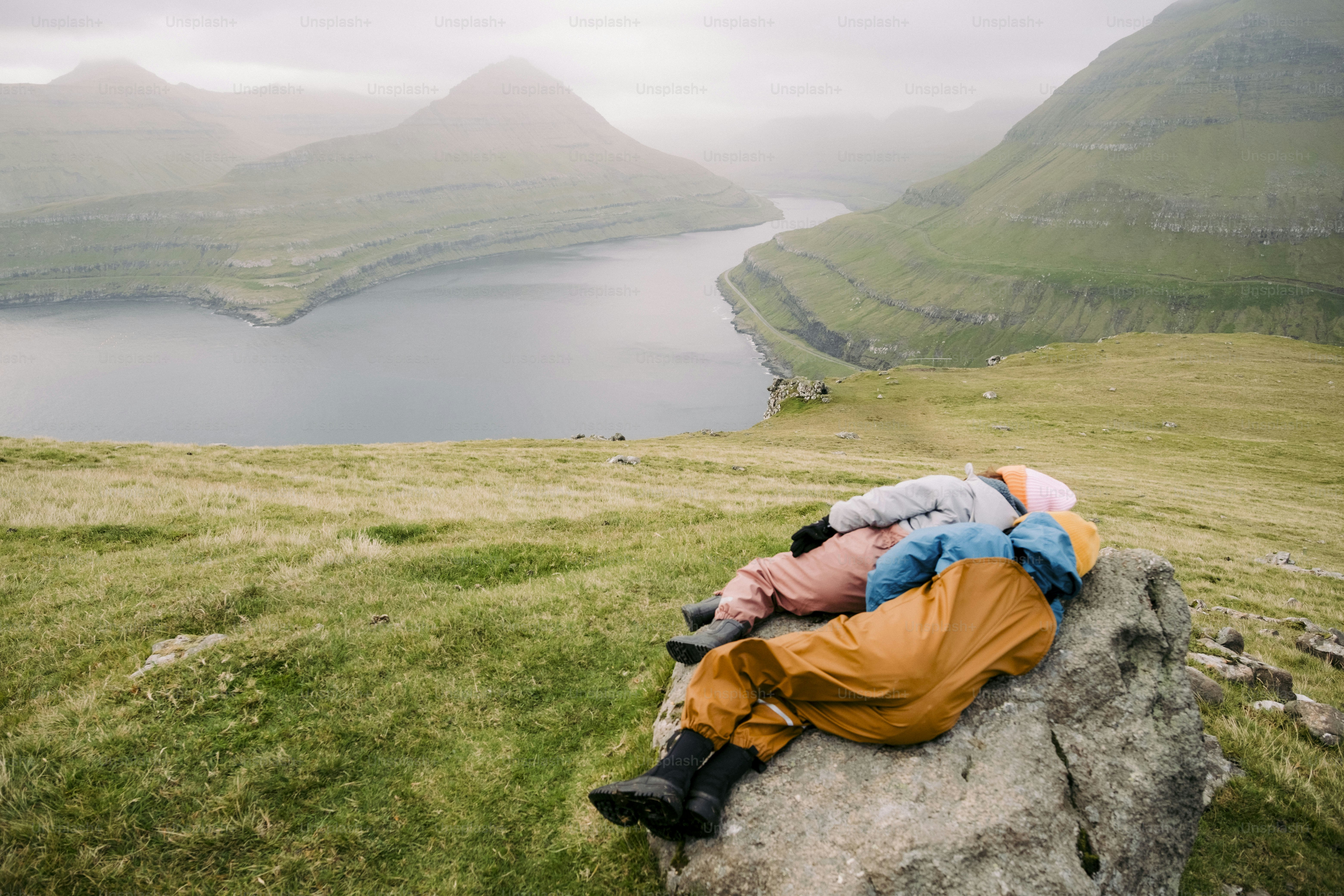 People rest on a rock overlooking a beautiful landscape. photo – Travel ...