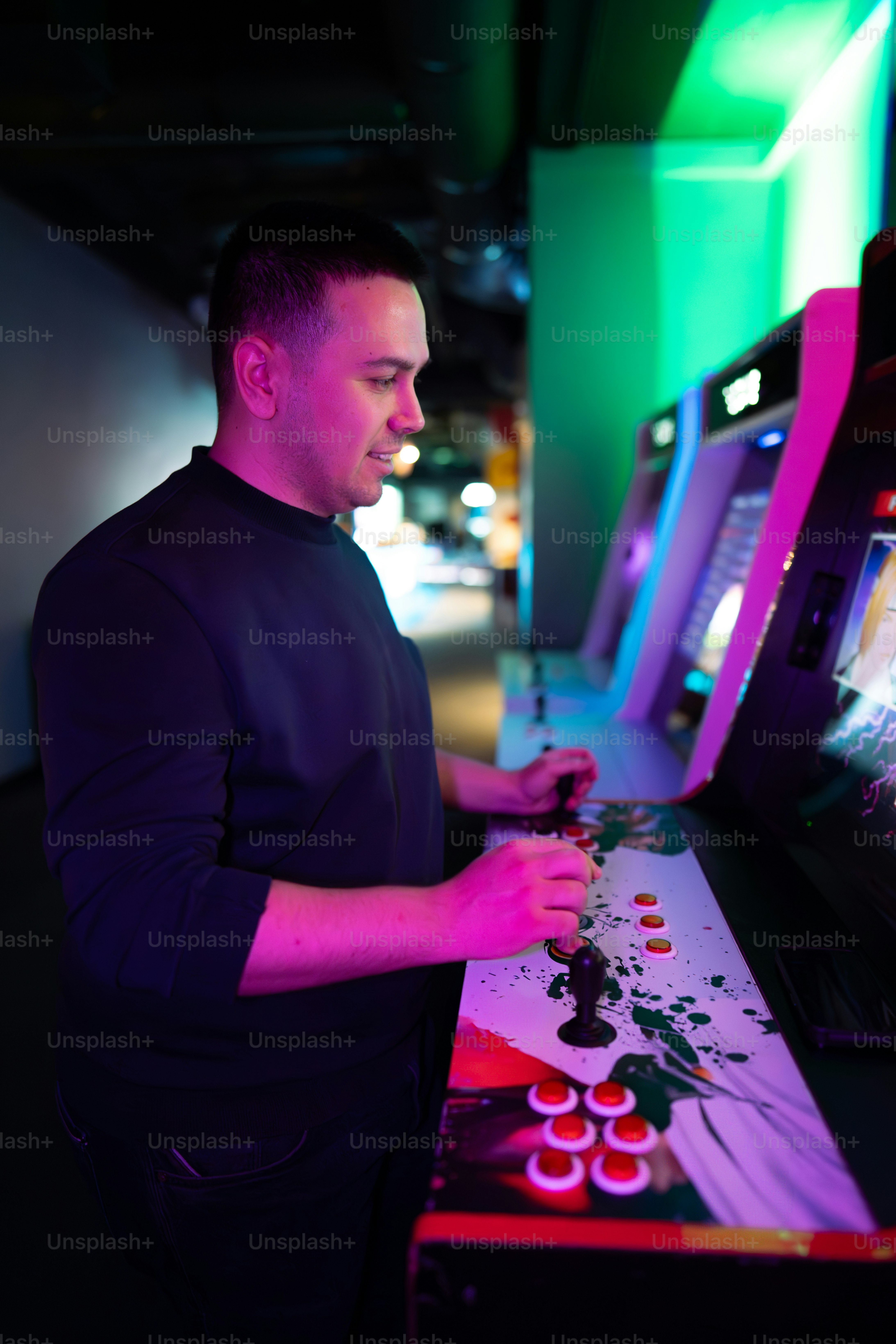 Man playing arcade games in a dimly lit arcade. photo – Gaming Image on ...
