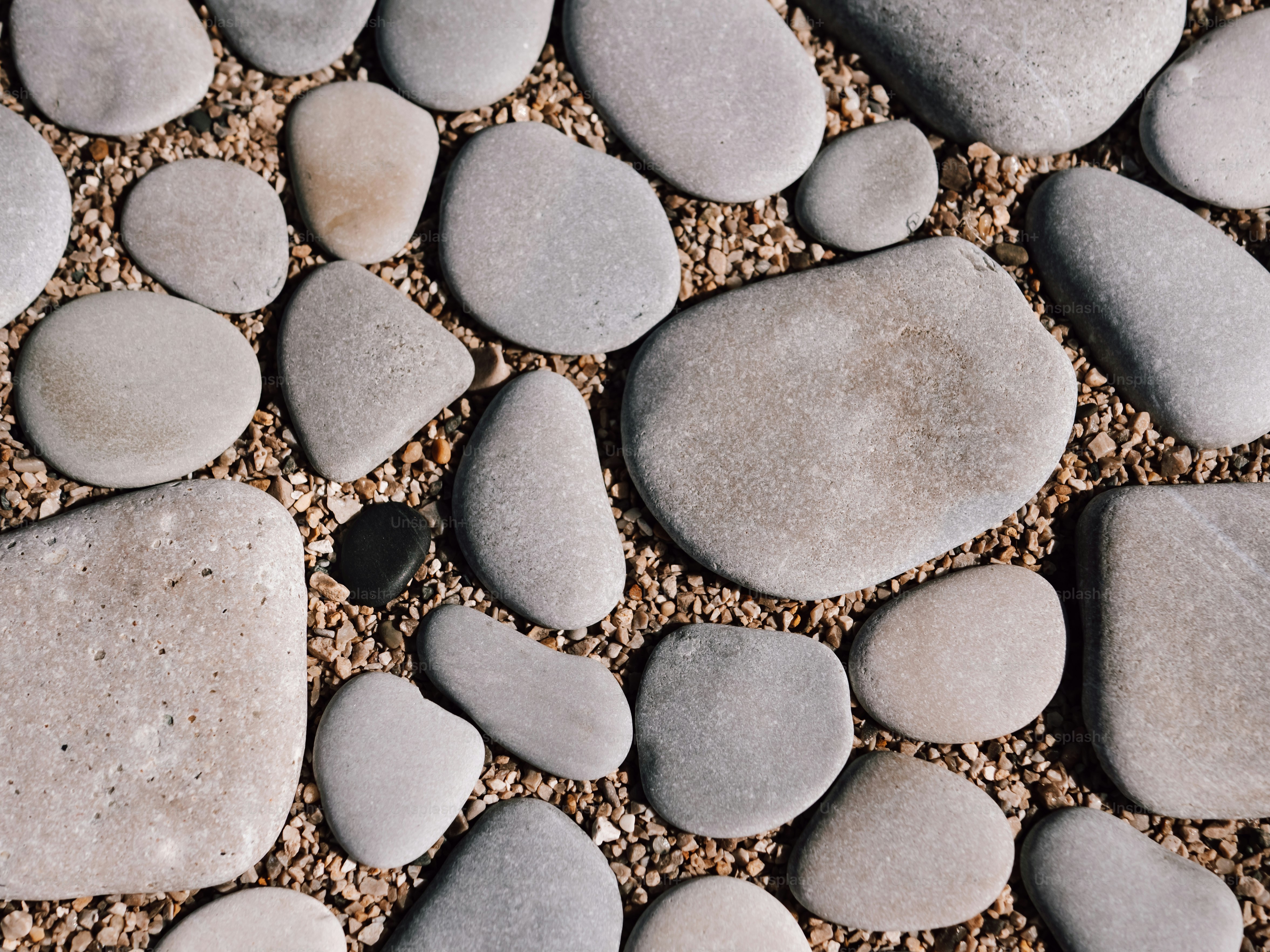 Smooth stones lay on a bed of small pebbles. photo – Wallpaper Image on ...