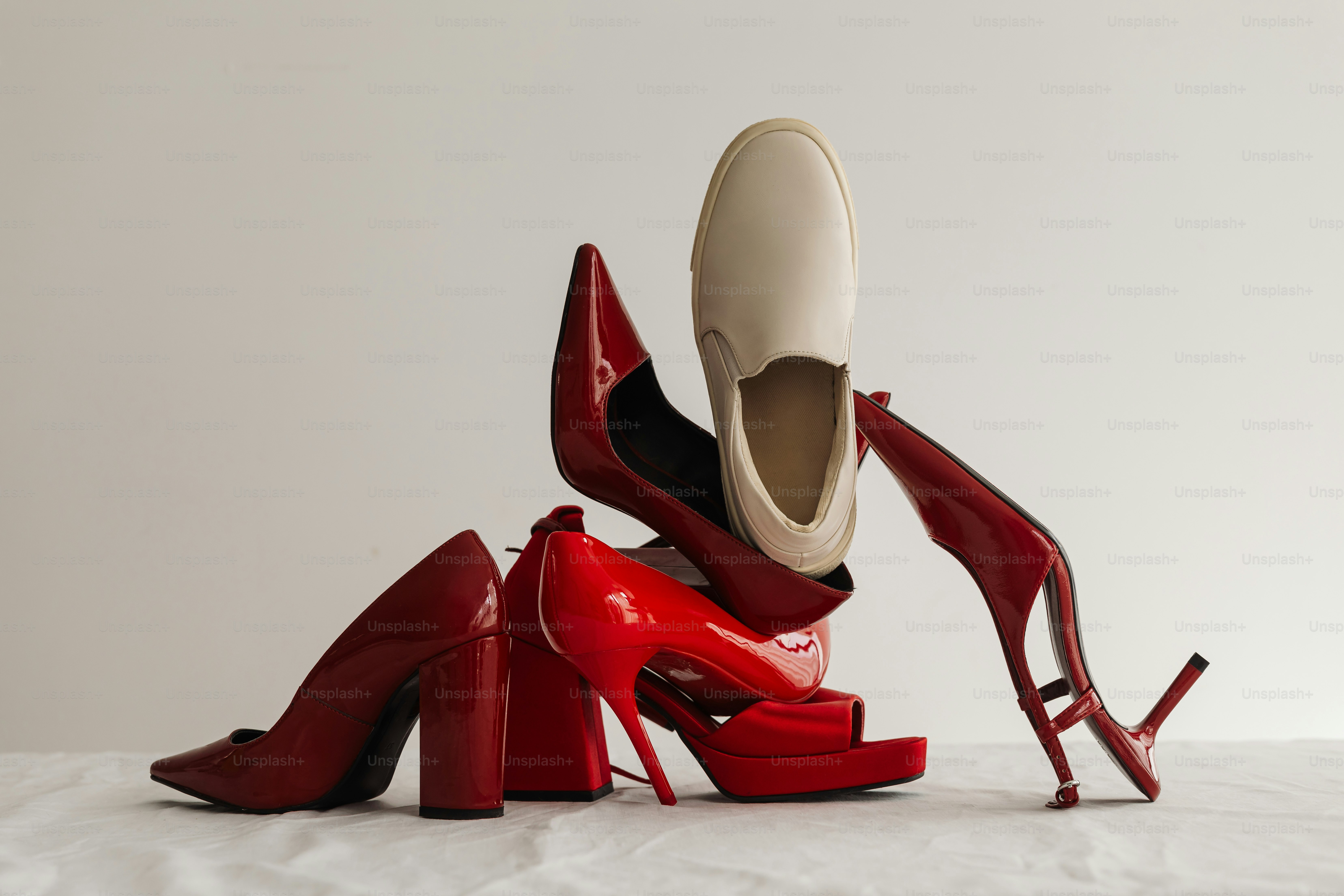 Shoes of varying styles are stacked together. photo – Shoes Image on ...