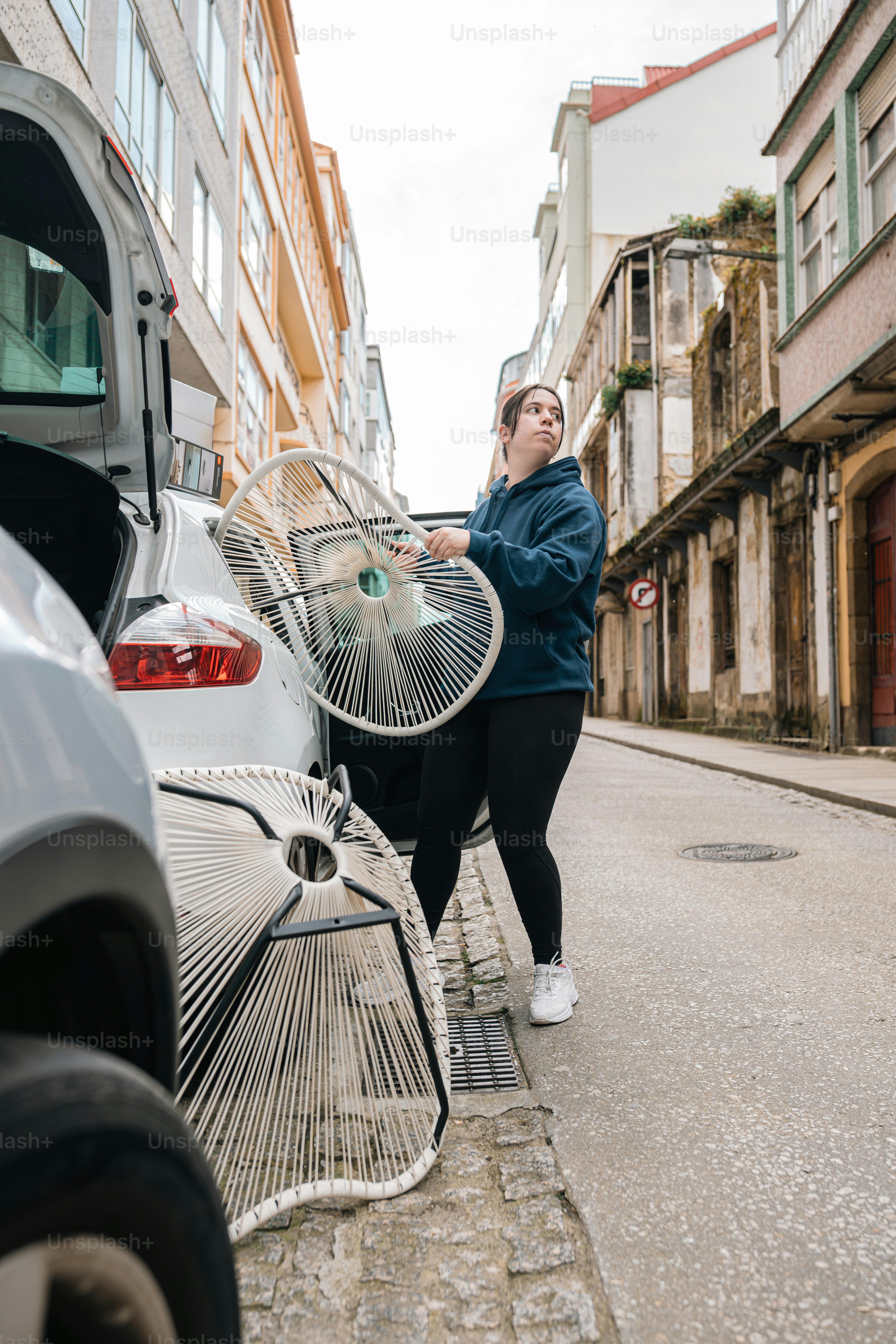Woman unloading items from the car on a street. photo – Moving Image on ...