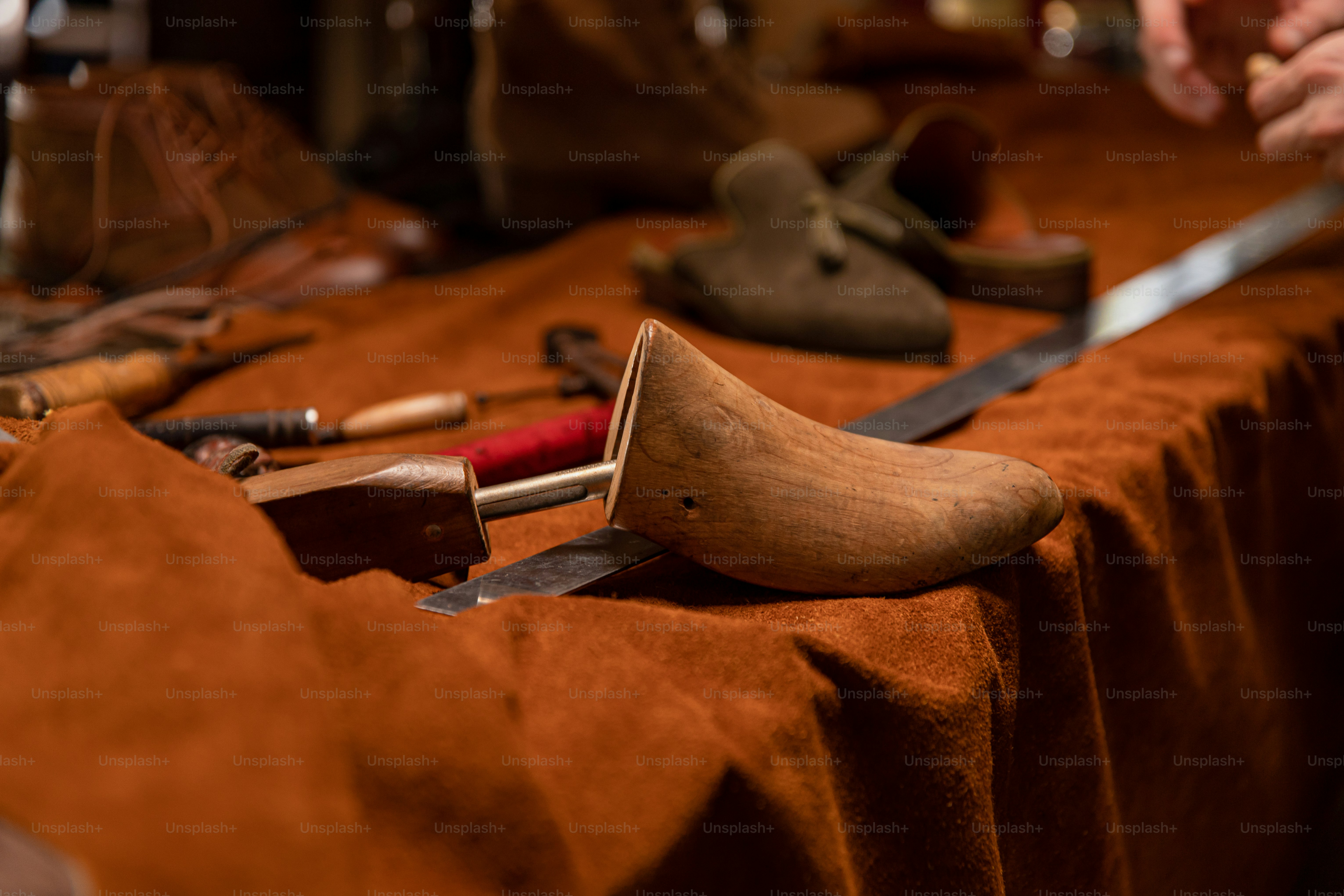 Shoemaking tools are on a leather covered table. photo – Luxury Image on Unsplash