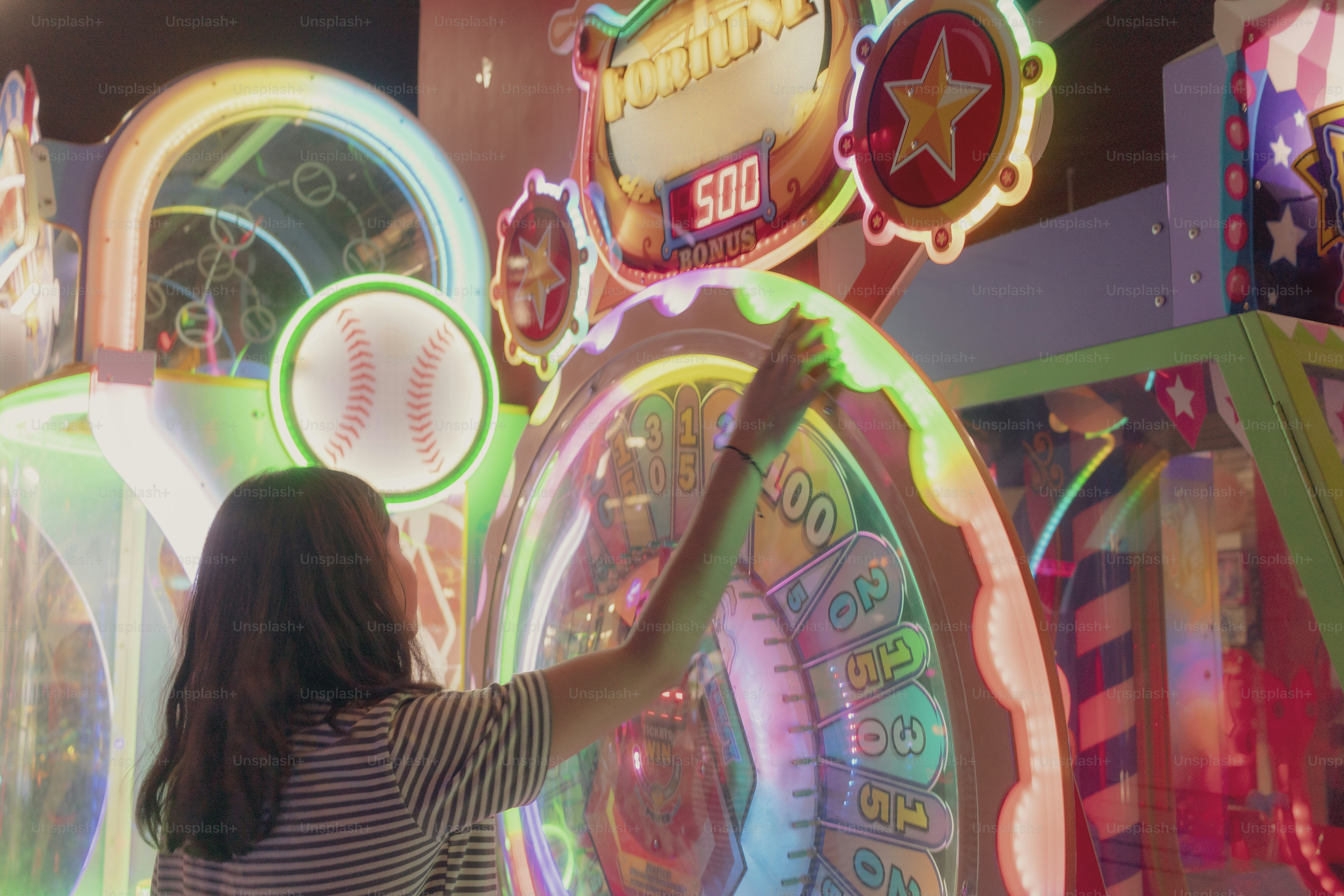 A person plays games at an arcade. photo – Gaming Image on Unsplash