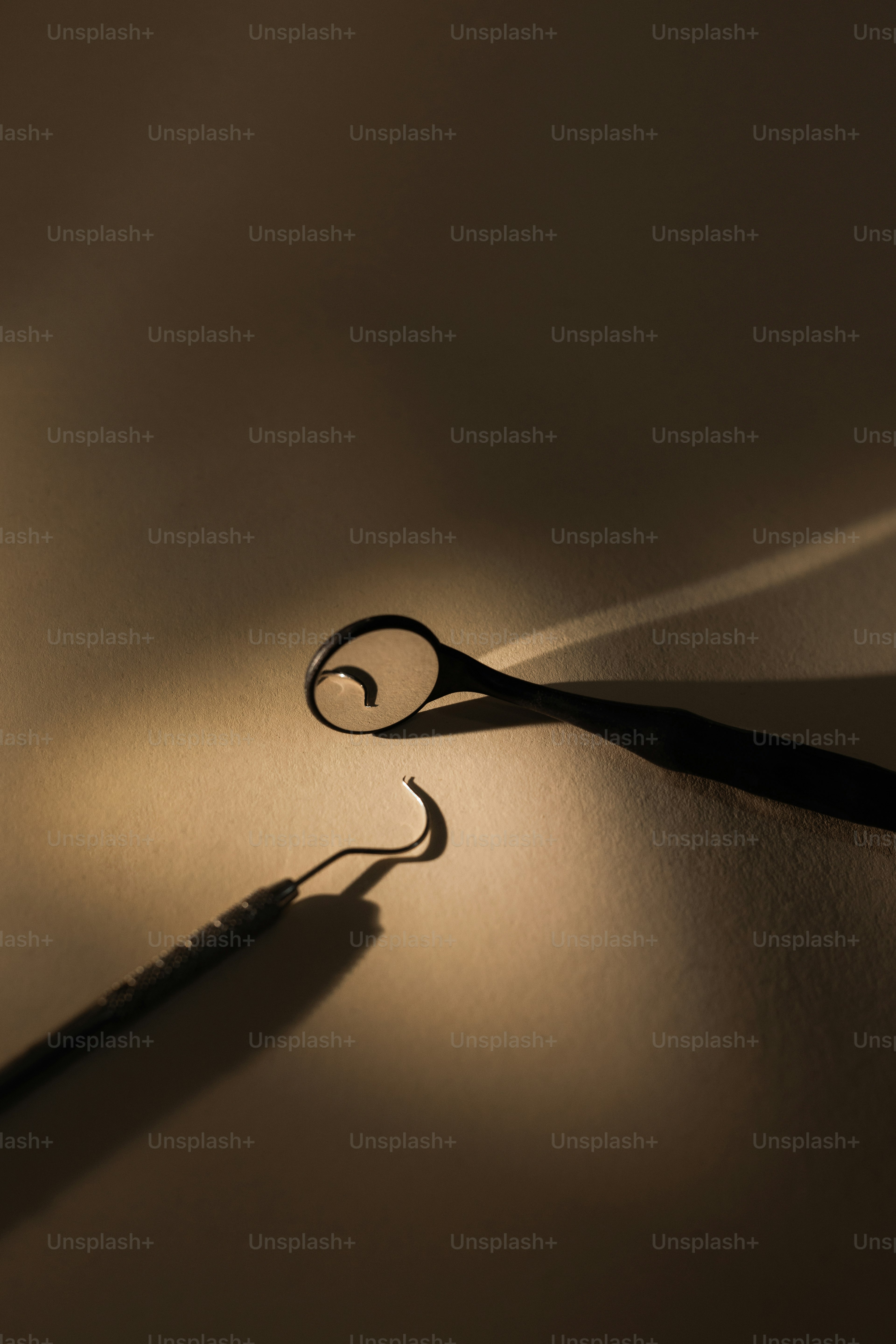 Dental instruments cast dramatic shadows on a surface. photo – Dental ...