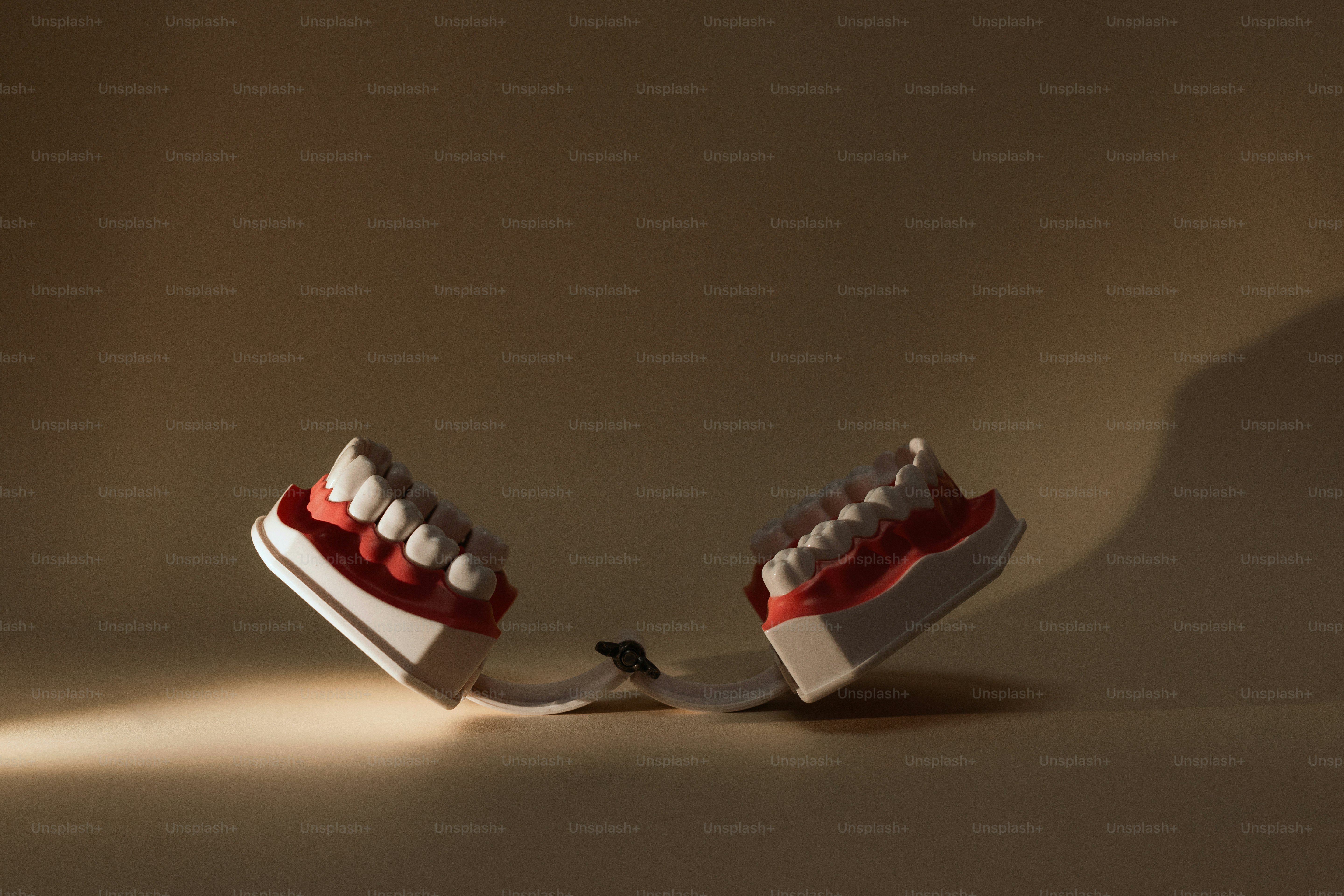 Los dientes artificiales yacen abiertos sobre un fondo neutro. foto ...